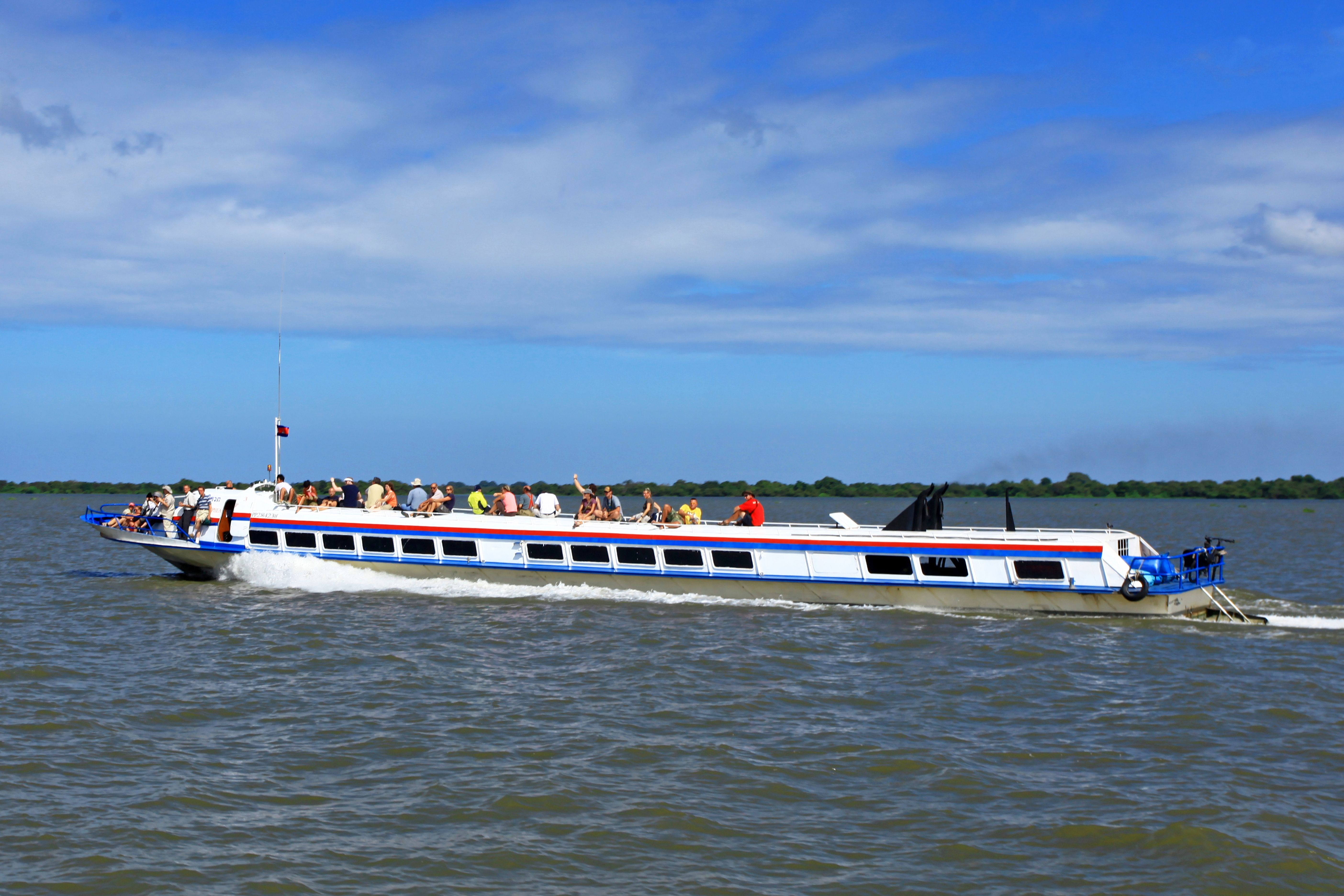 Passenger Boat Cruising on Open Water under Blue Sky · Free Stock Photo