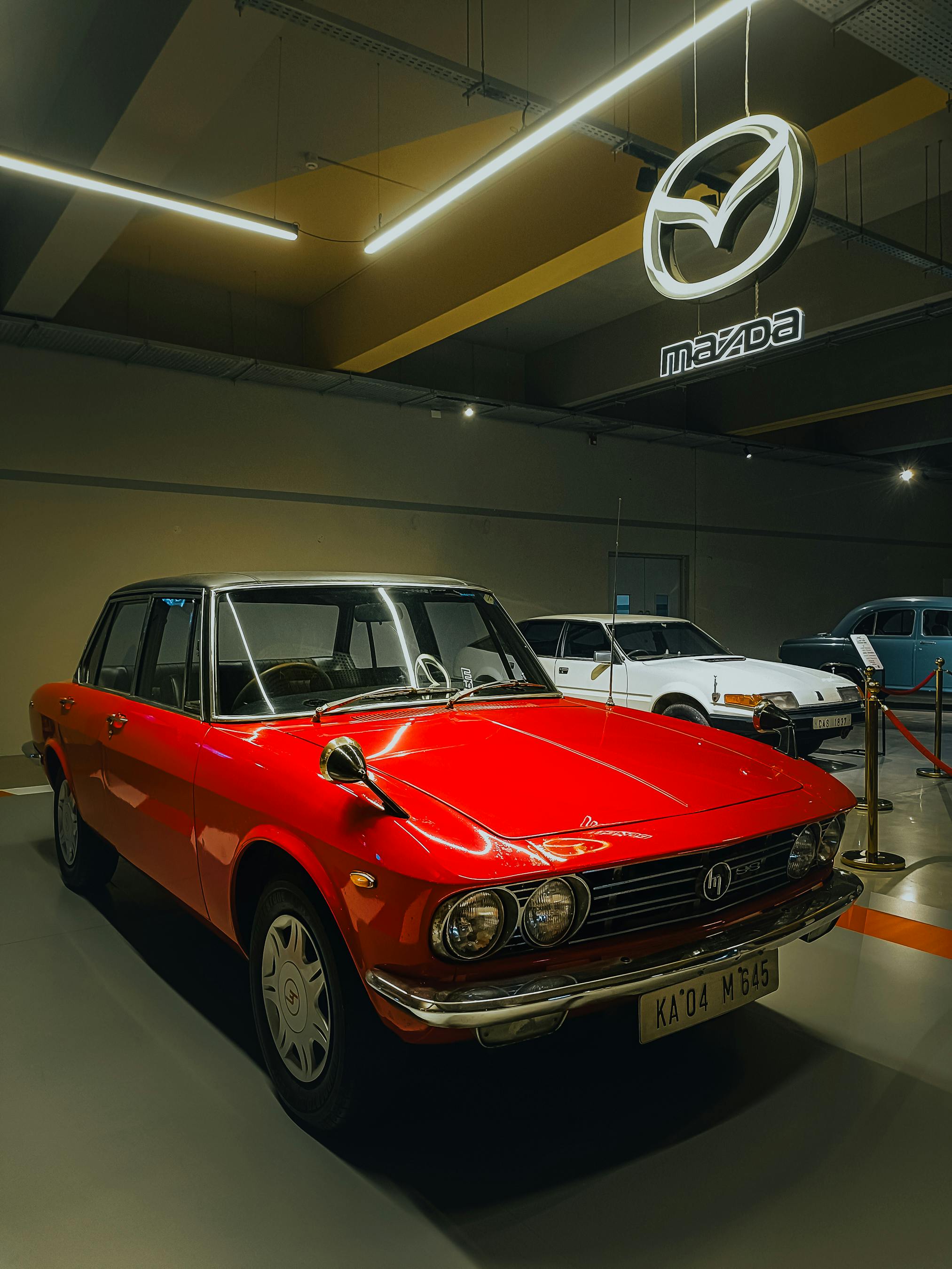 Vintage Red Mazda Car in Indoor Exhibition · Free Stock Photo