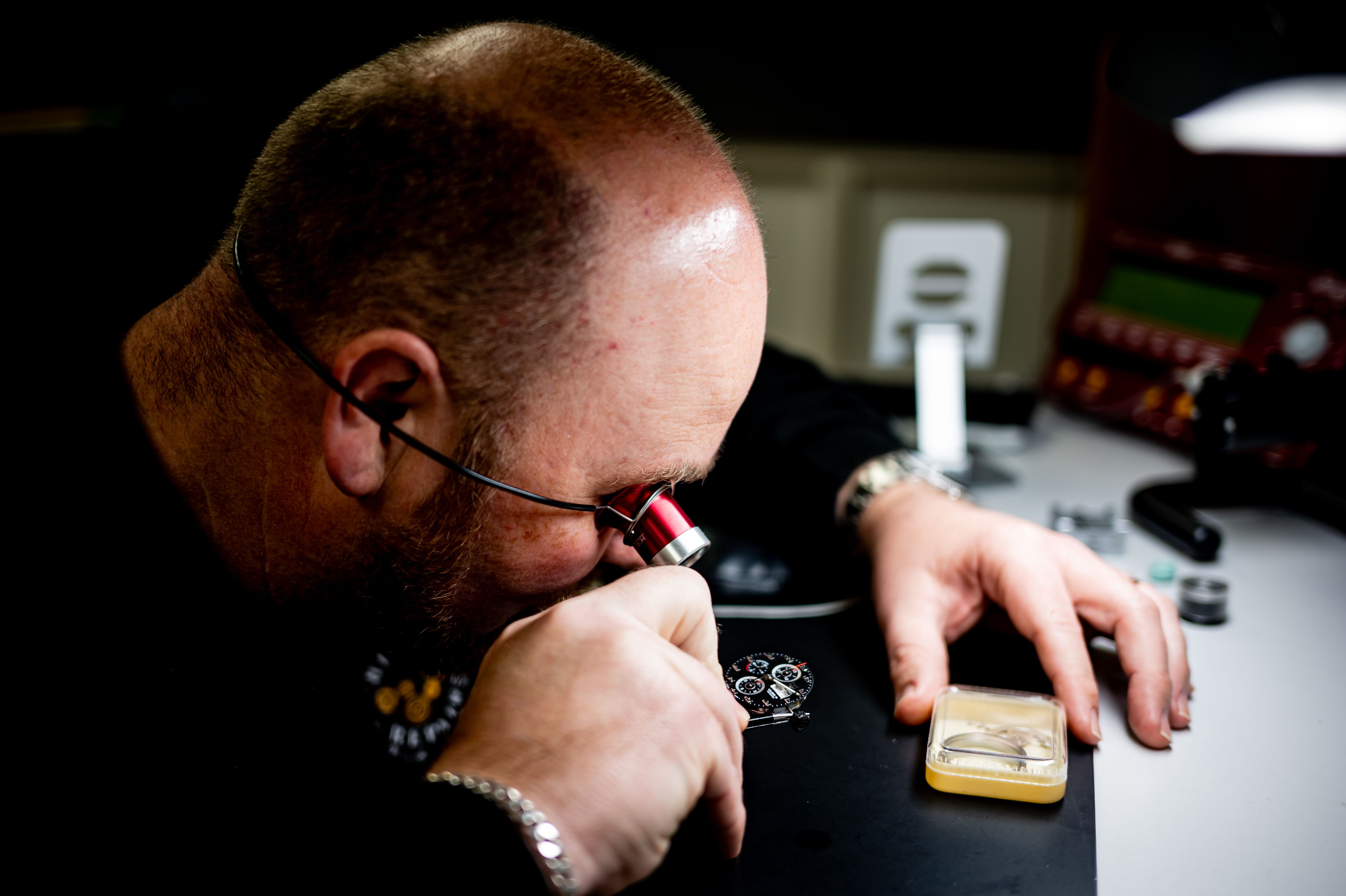 Watchmaker Examining Timepiece with Magnifier · Free Stock Photo