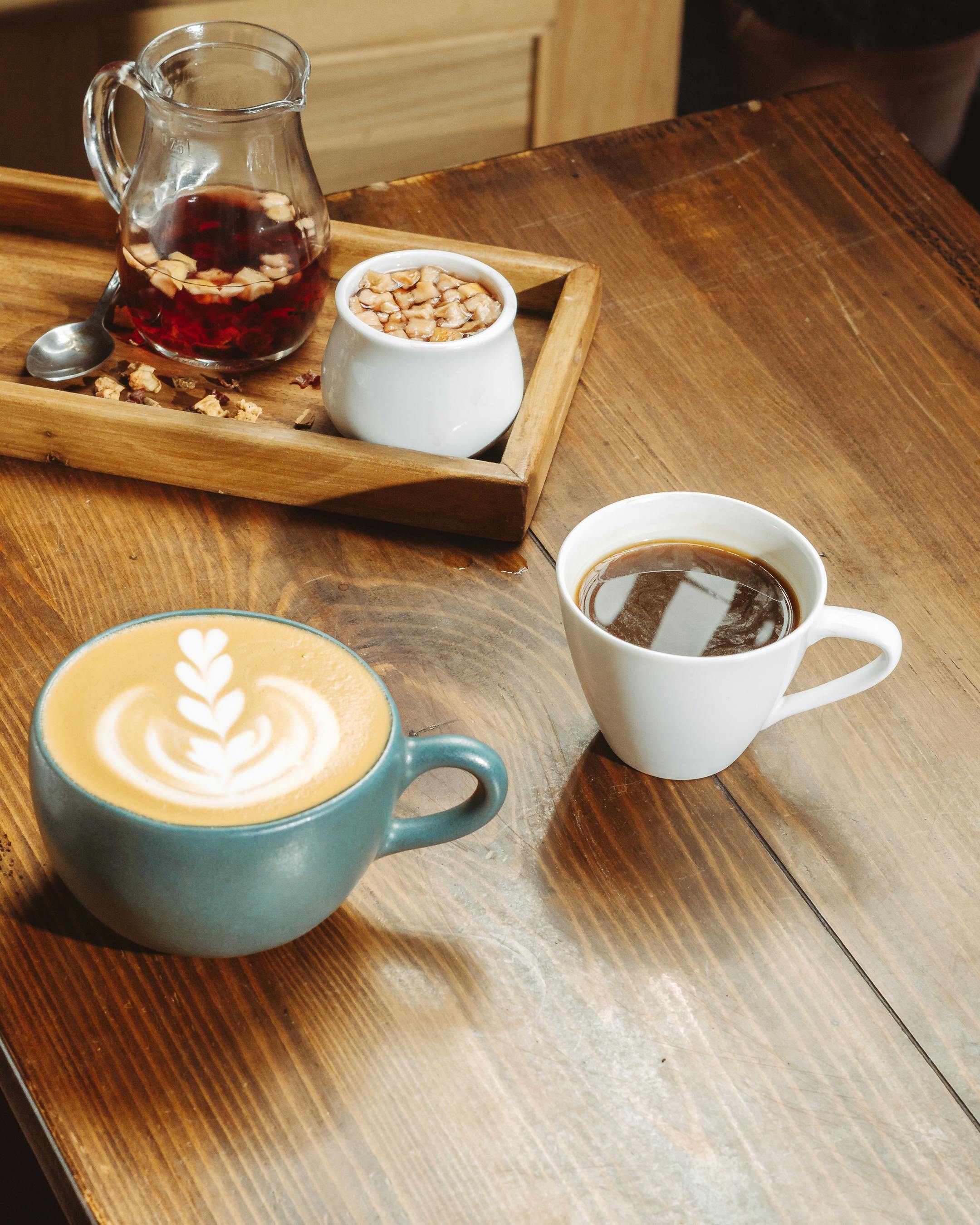 Latte Art and Teas on Rustic Wooden Table · Free Stock Photo