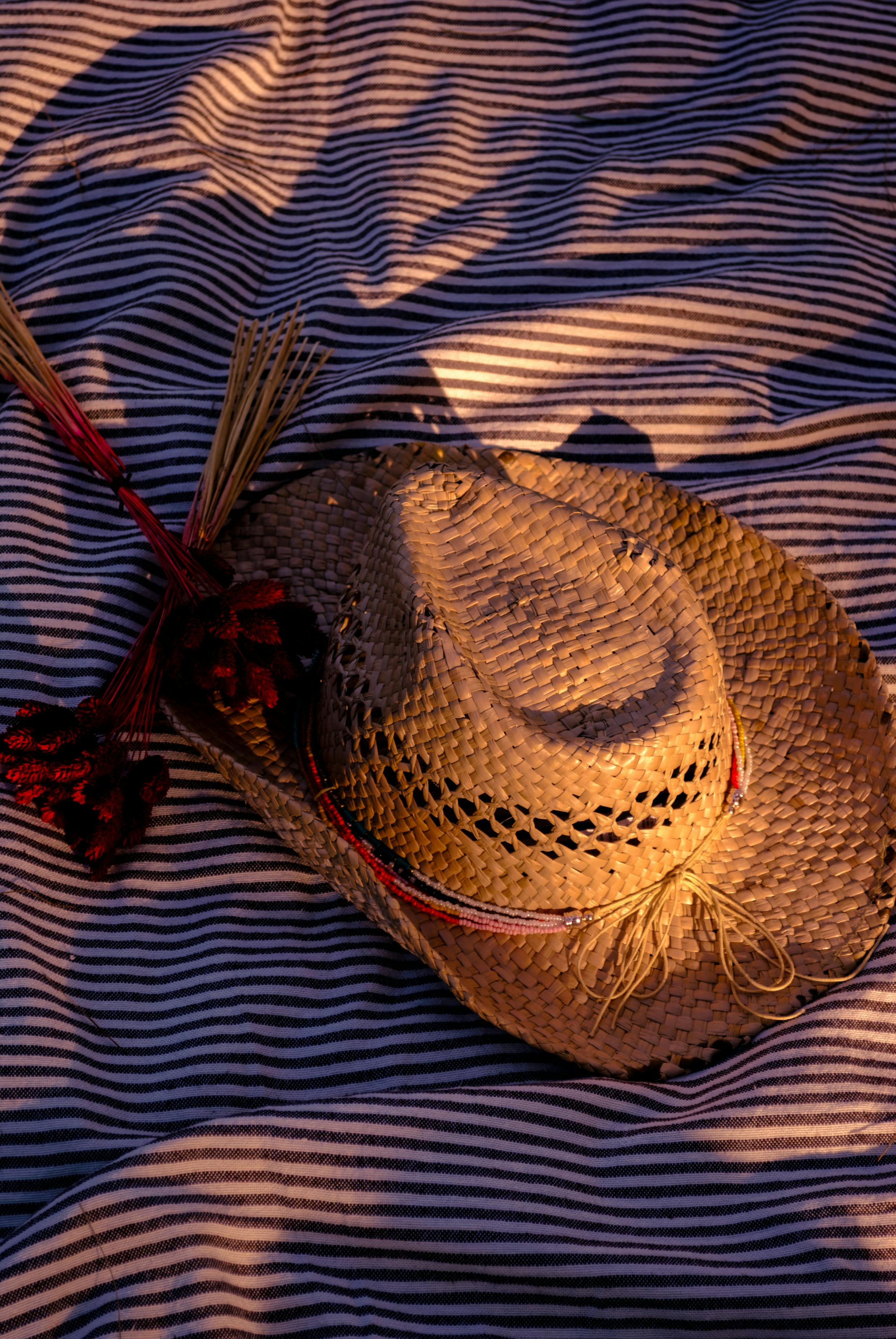 Rustic Straw Hat on Striped Blanket in Sunset Light · Free Stock Photo