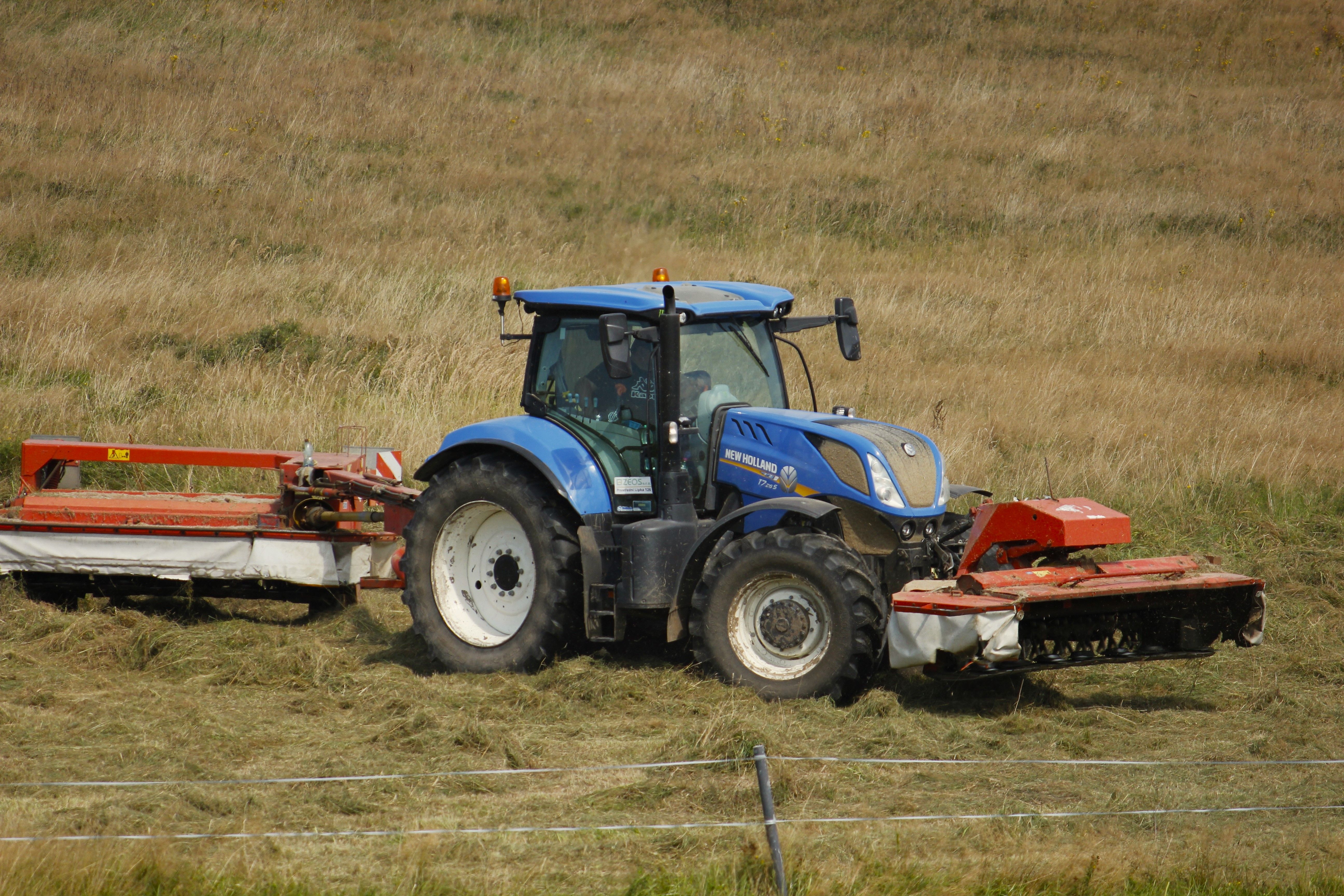 Blue Tractor in Field Harvesting Crops · Free Stock Photo