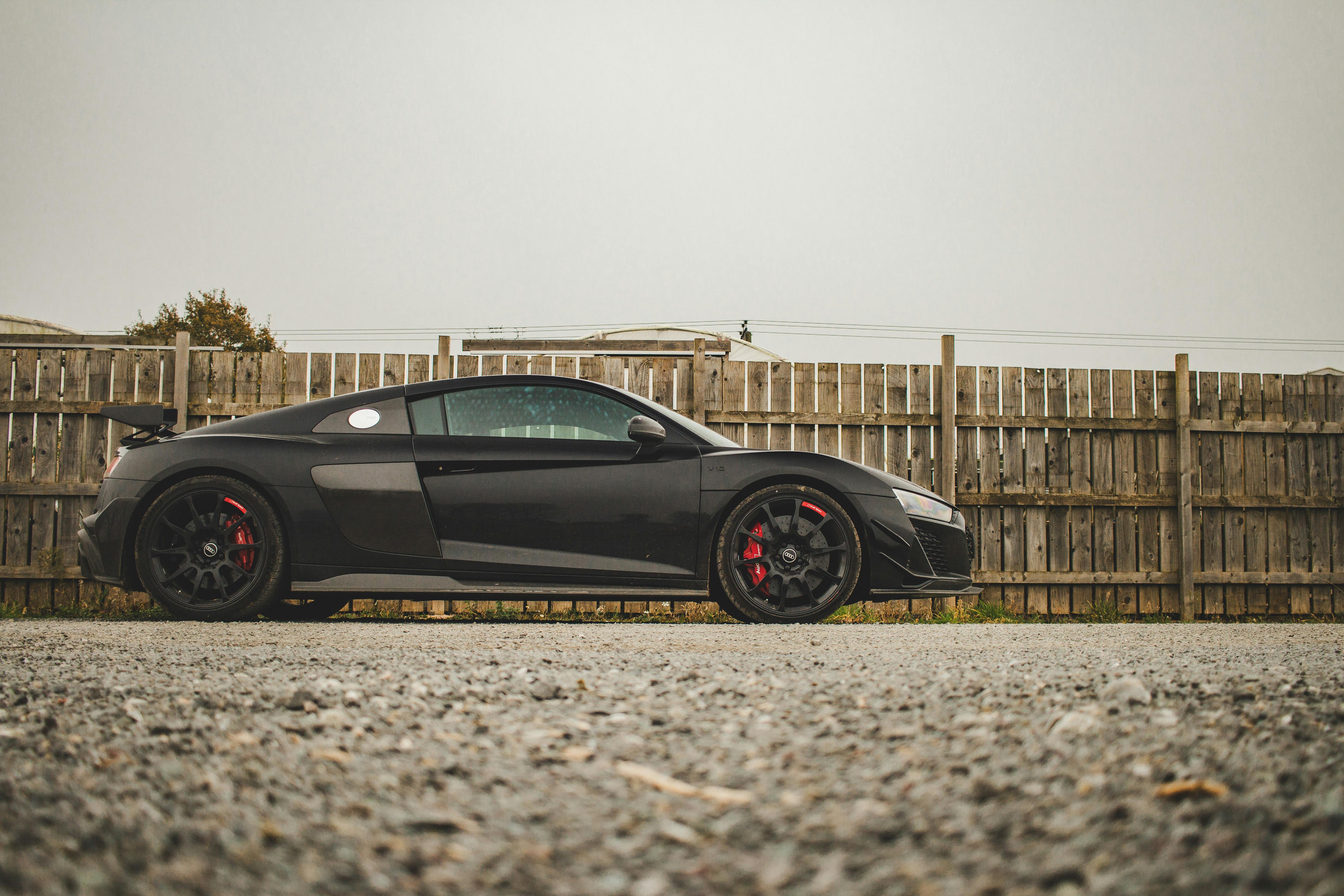 Luxury Black Sports Car on Gravel Road · Free Stock Photo