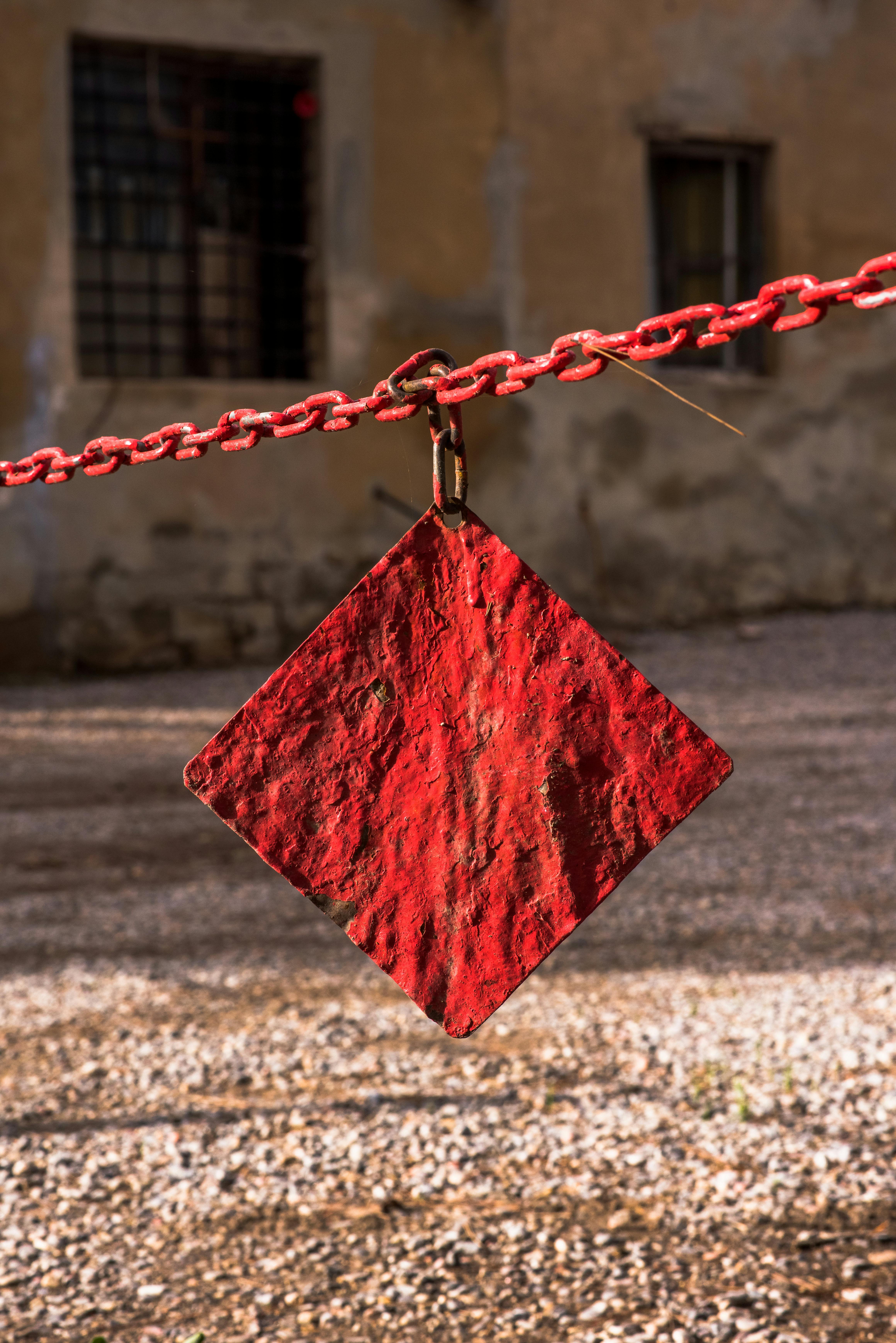 Red Metal Warning Sign on Chain Outdoors · Free Stock Photo
