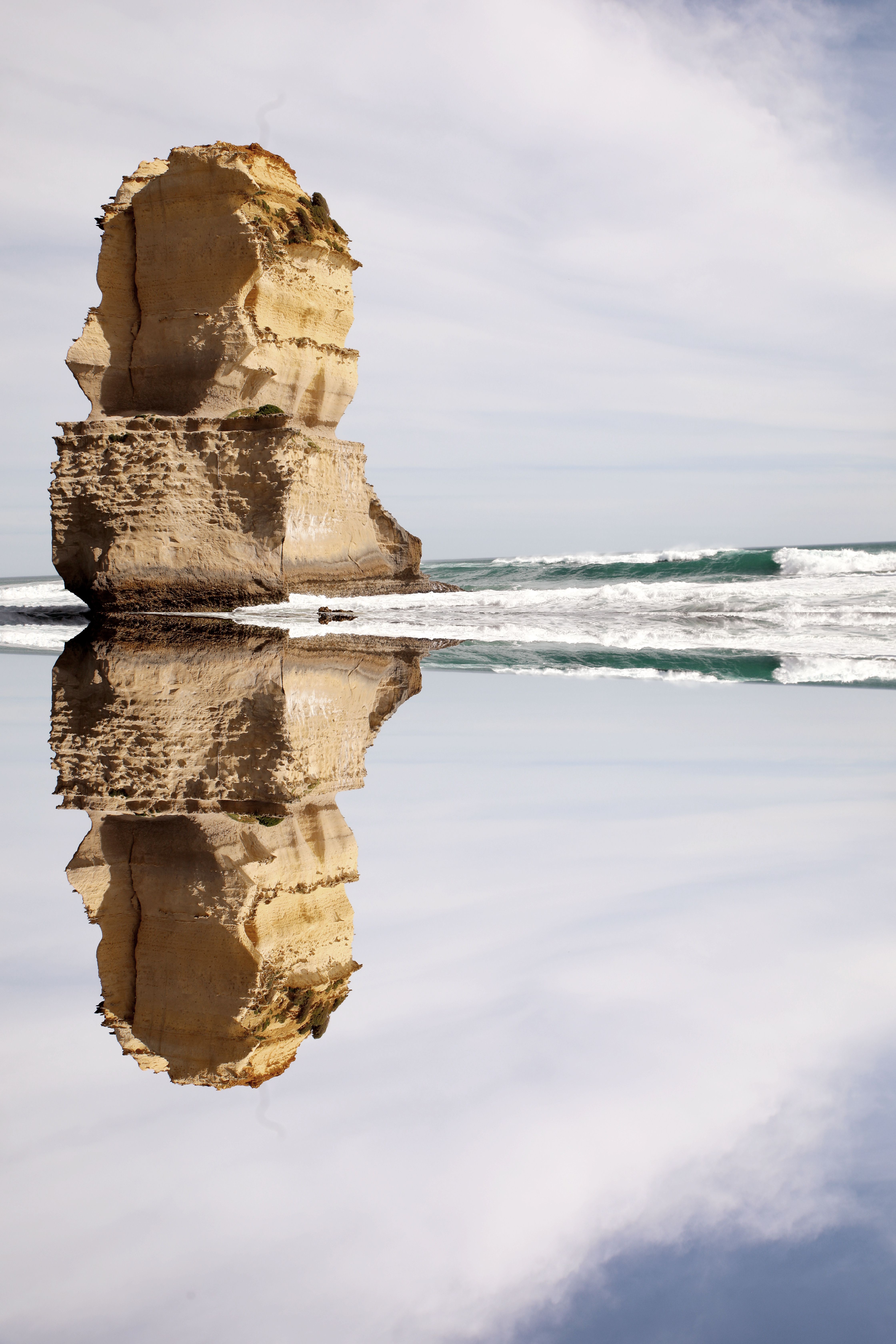 Majestic Coastal Rock Formation Reflecting in Water · Free Stock Photo