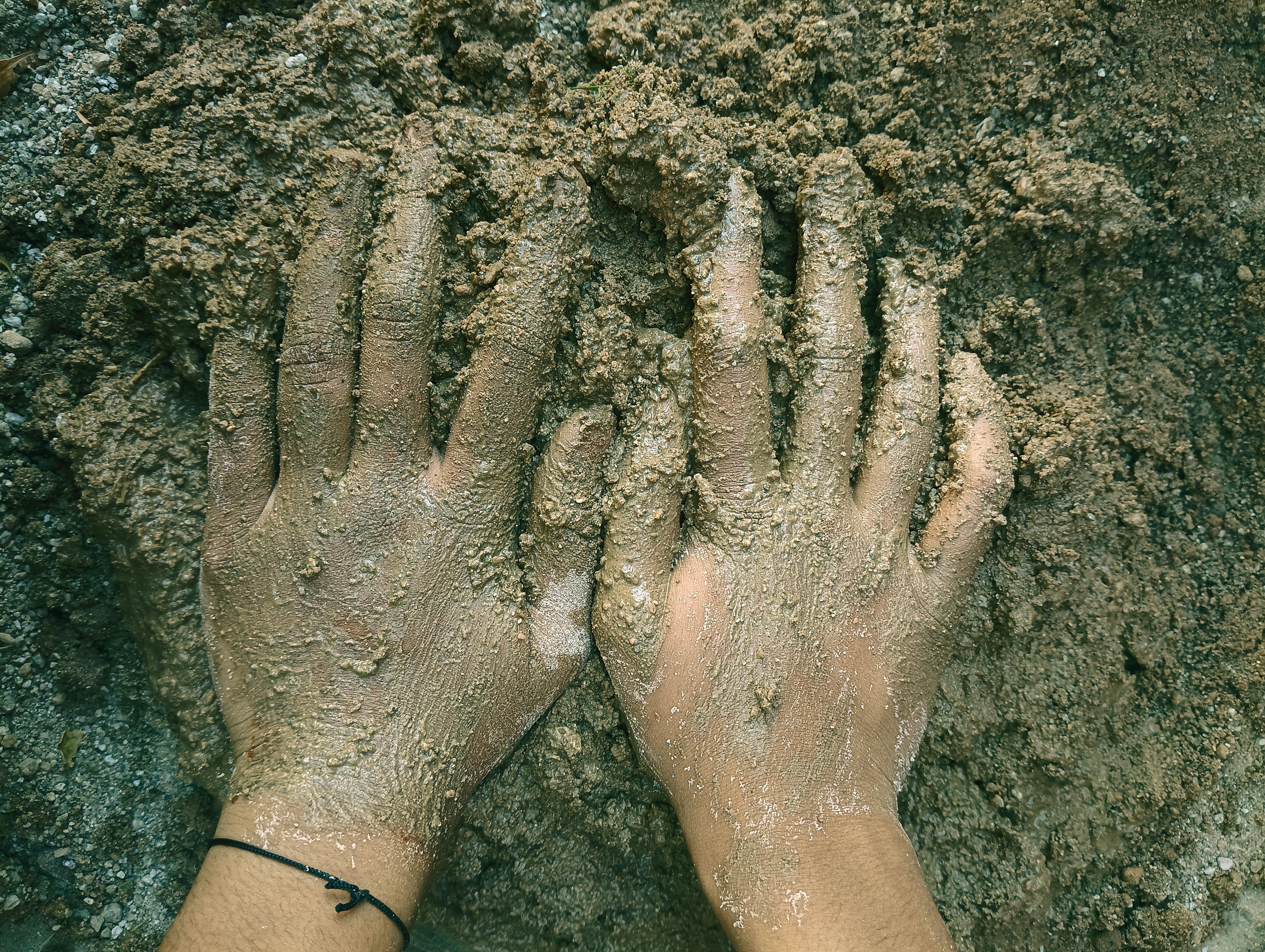 Close-up of Hands in Muddy Clay Outdoors · Free Stock Photo