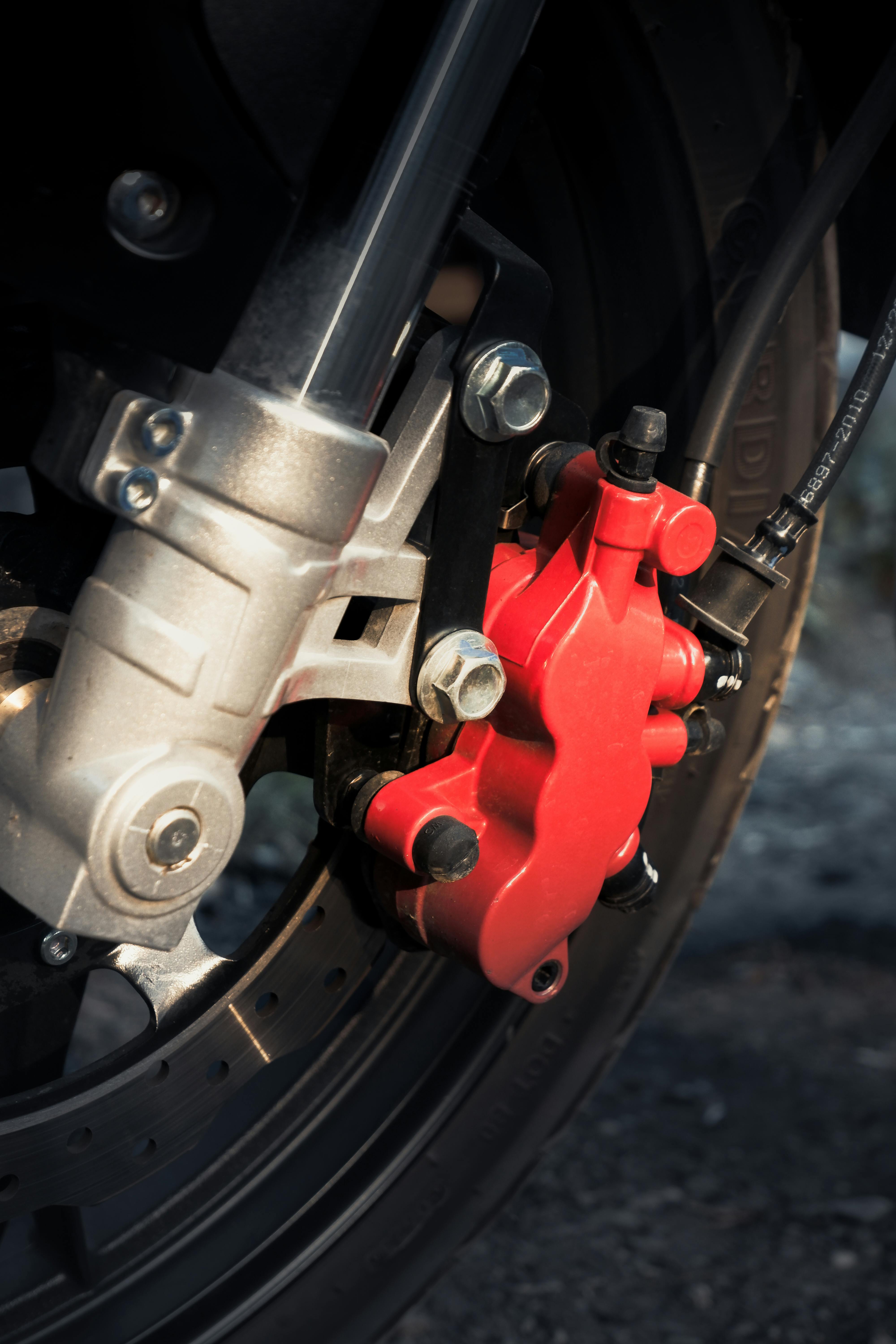 Close-up of Red Motorcycle Brake Caliper · Free Stock Photo