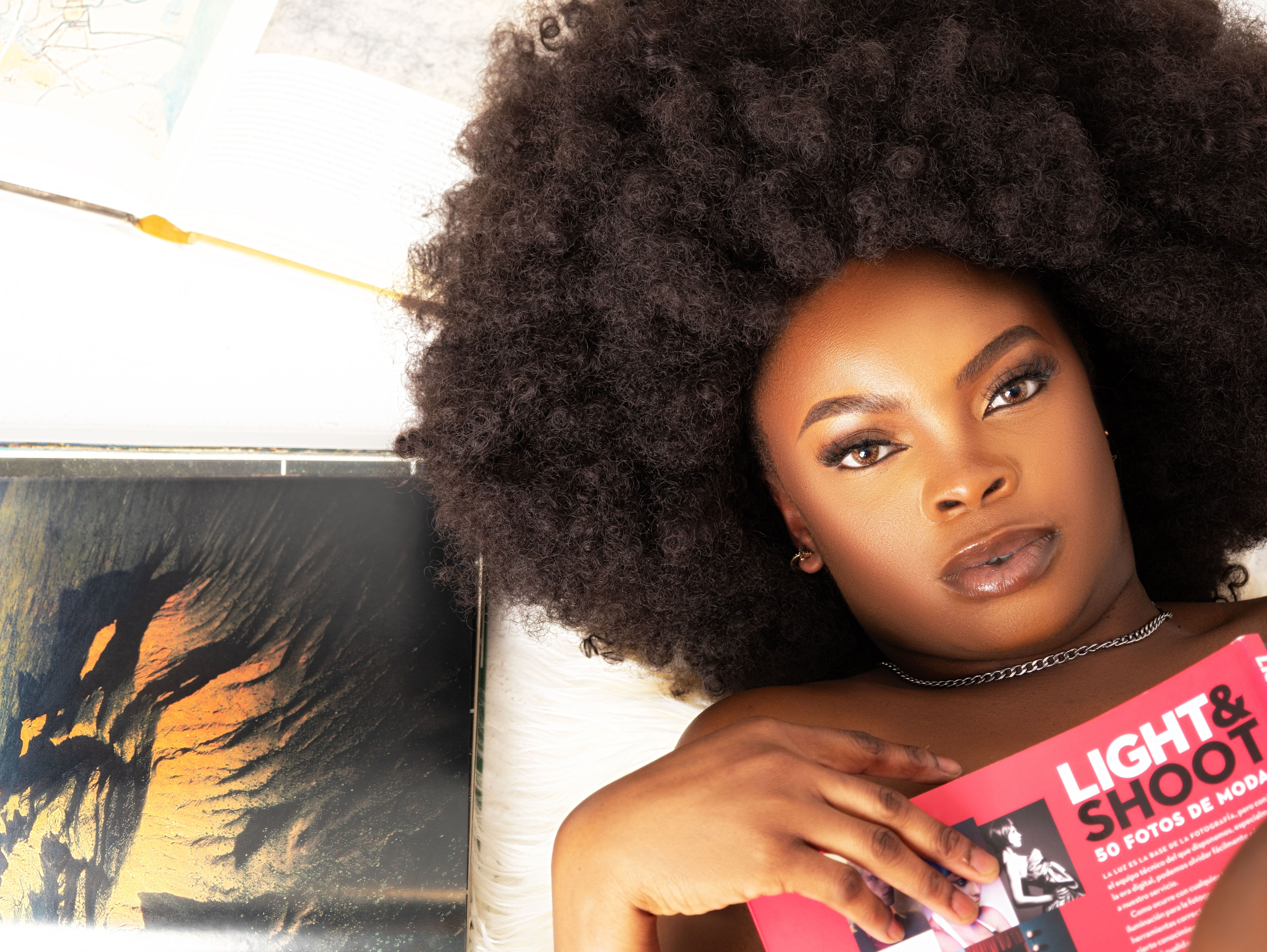 Portrait of Woman with Afro Hair Reading a Book · Free Stock Photo