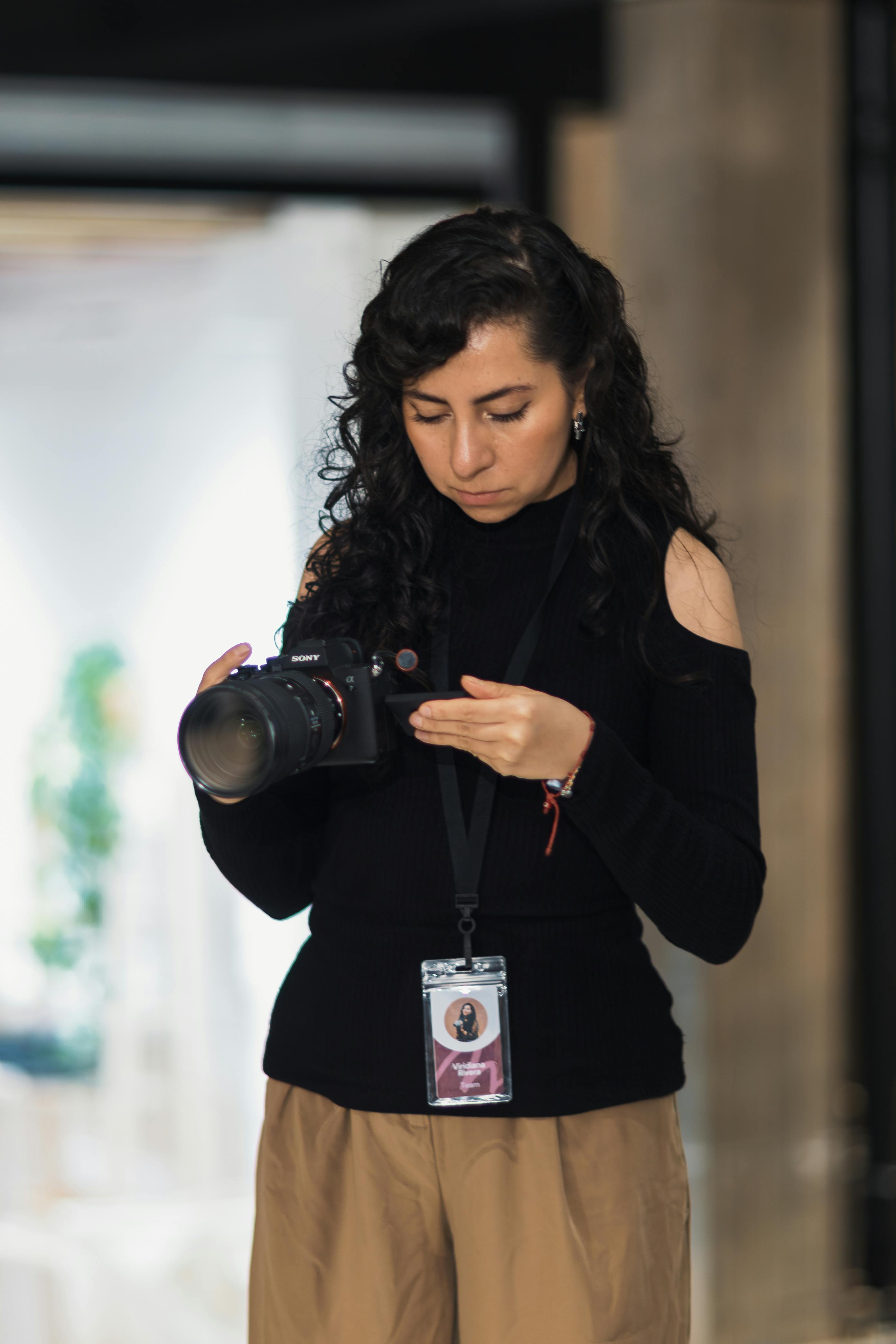 Focused Photographer Reviewing Camera Settings · Free Stock Photo