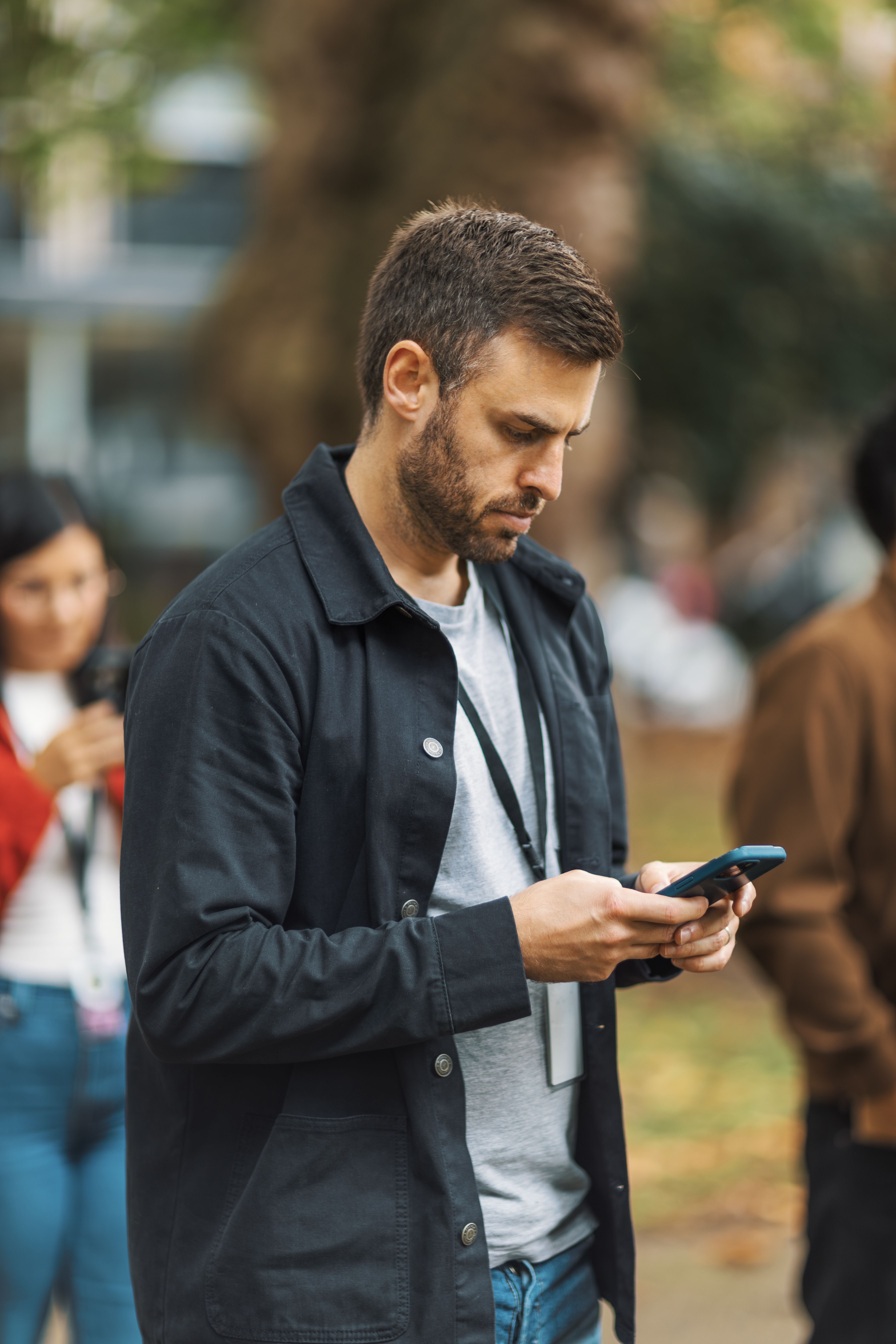 Man Using Smartphone in Outdoor Park Setting · Free Stock Photo