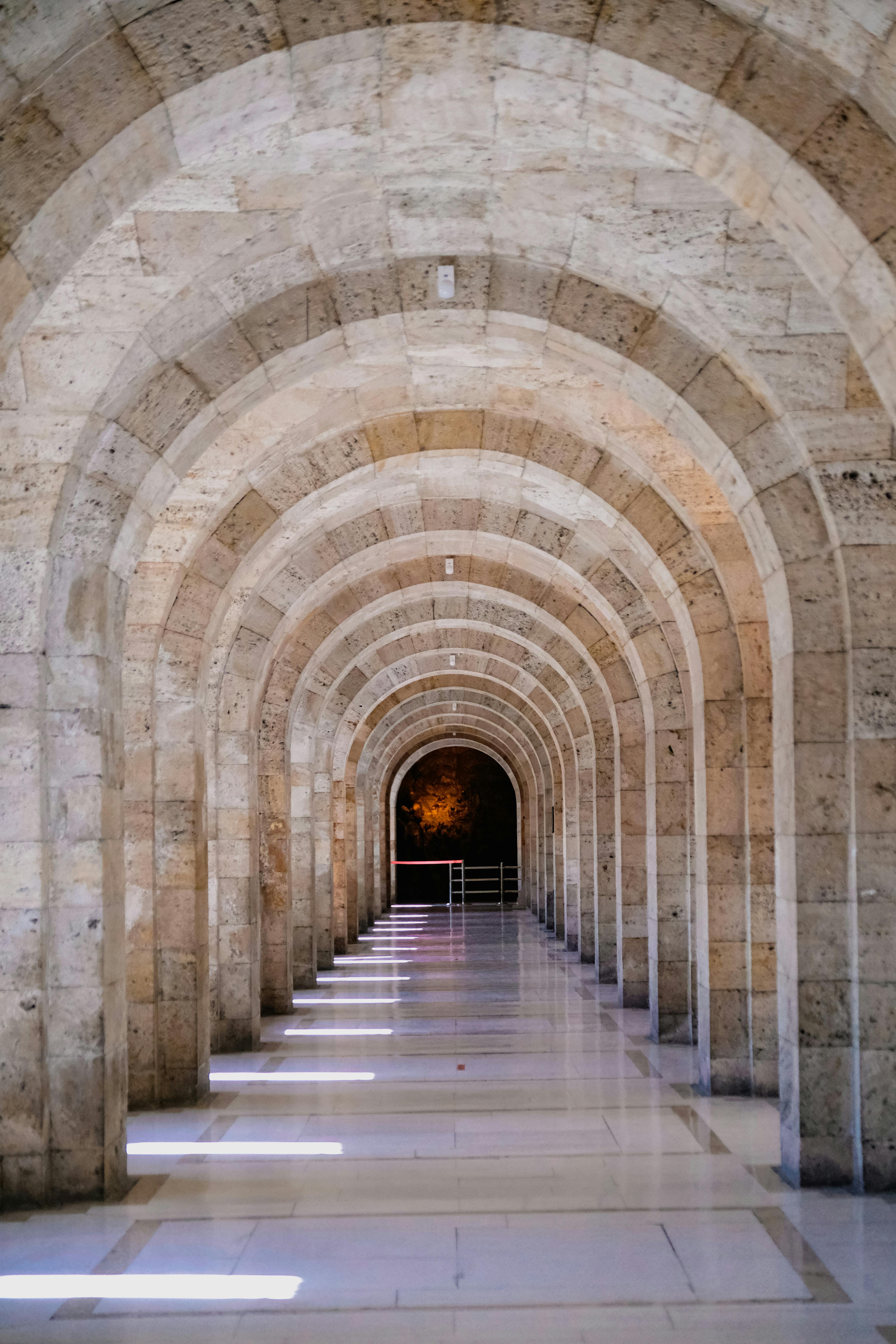 Elegant Stone Archway Corridor with Symmetrical Design · Free Stock Photo