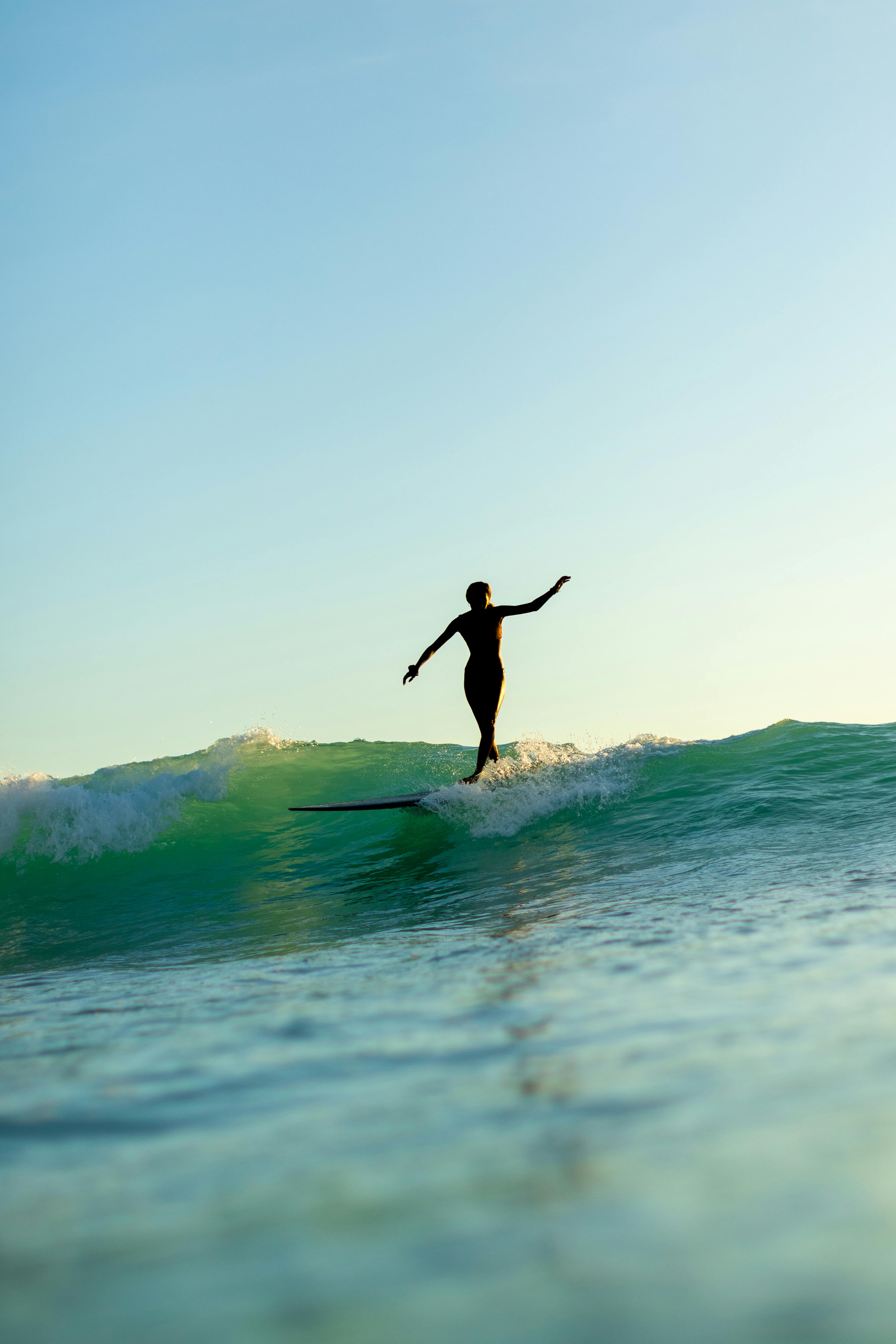 Una Surfista Practica Longboard Al Atardecer En Hawái · Foto de stock gratuita