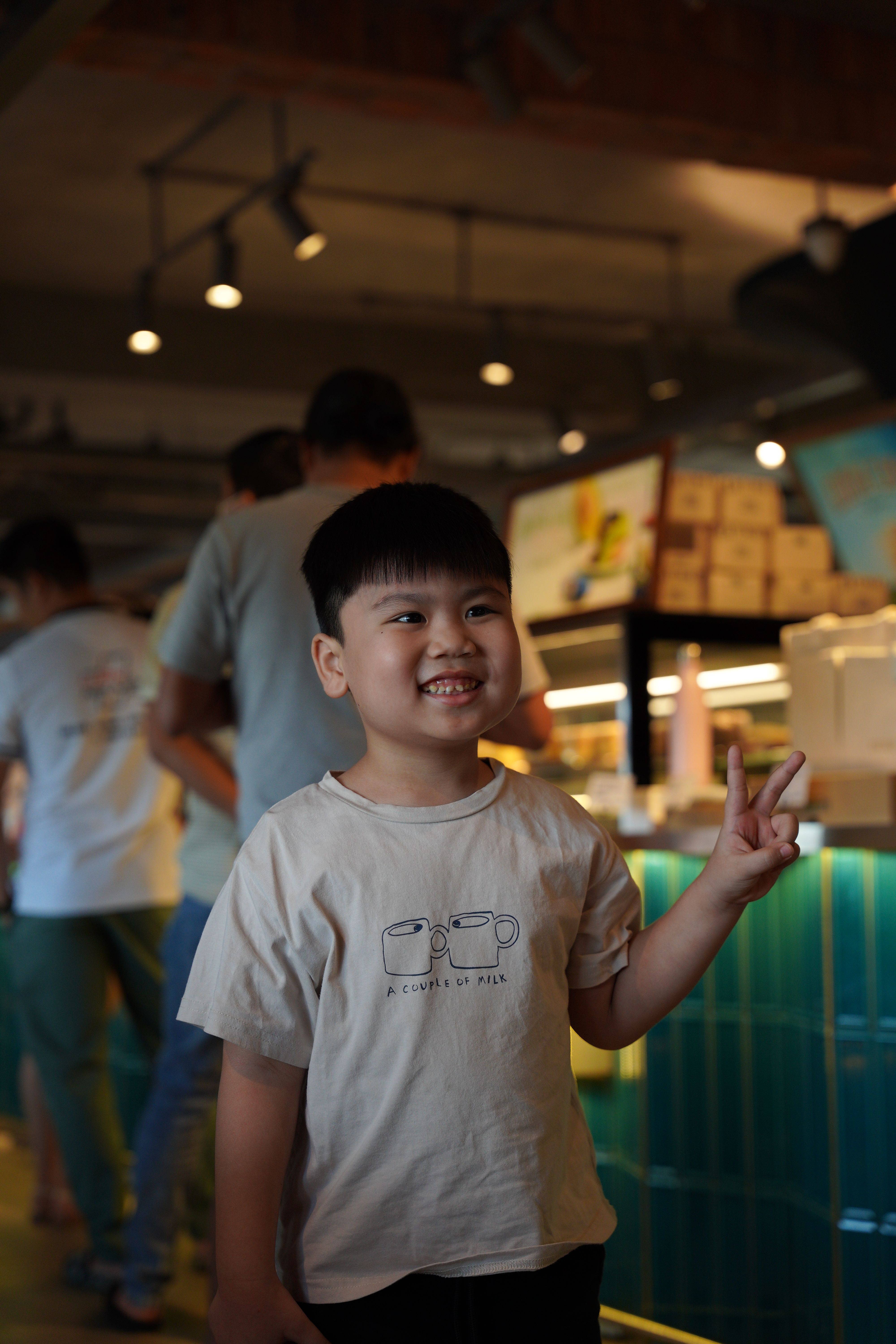 Cheerful Child in a Busy Cafe Setting · Free Stock Photo