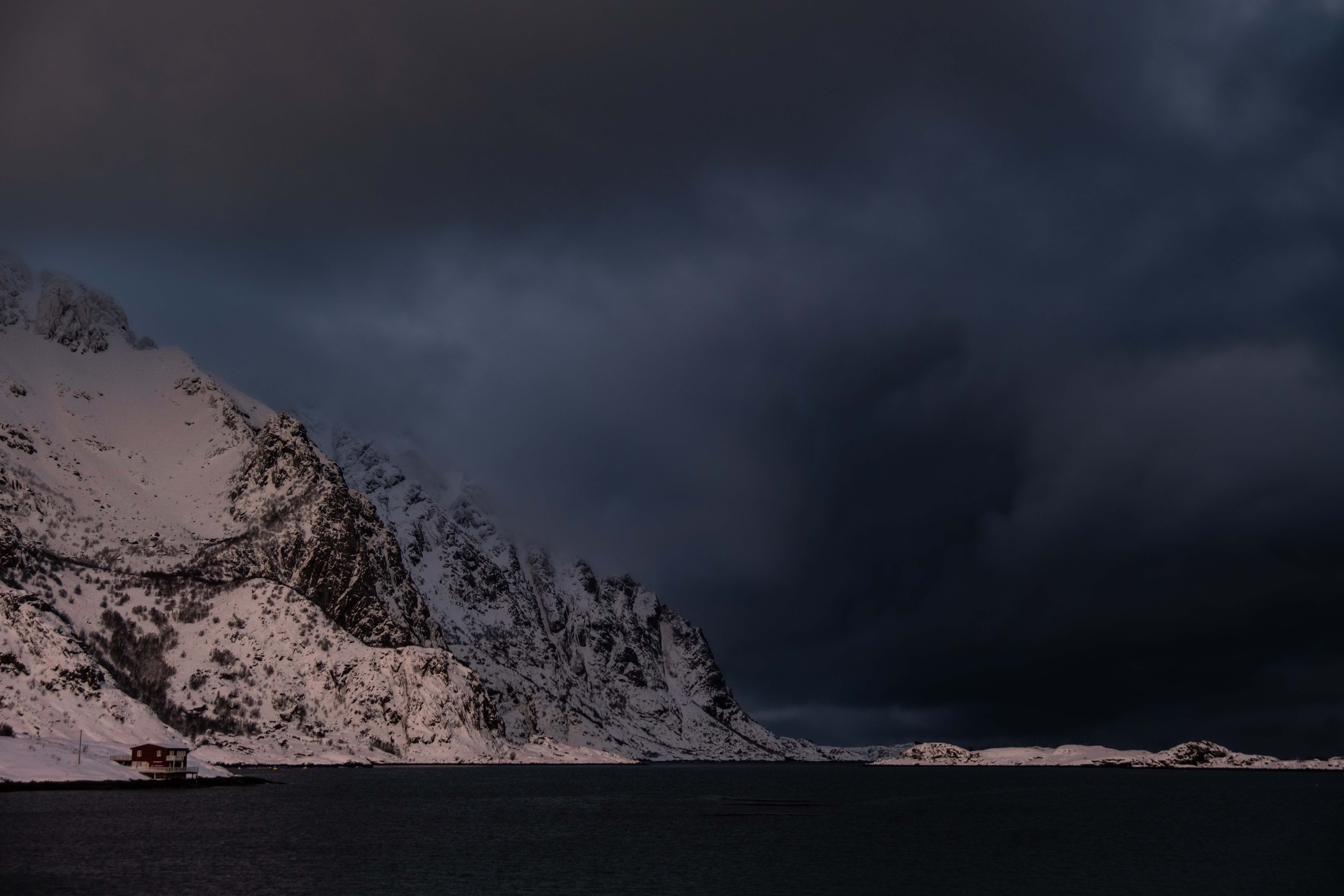 Dramatic Snow-Covered Mountains Under Stormy Skies · Free Stock Photo