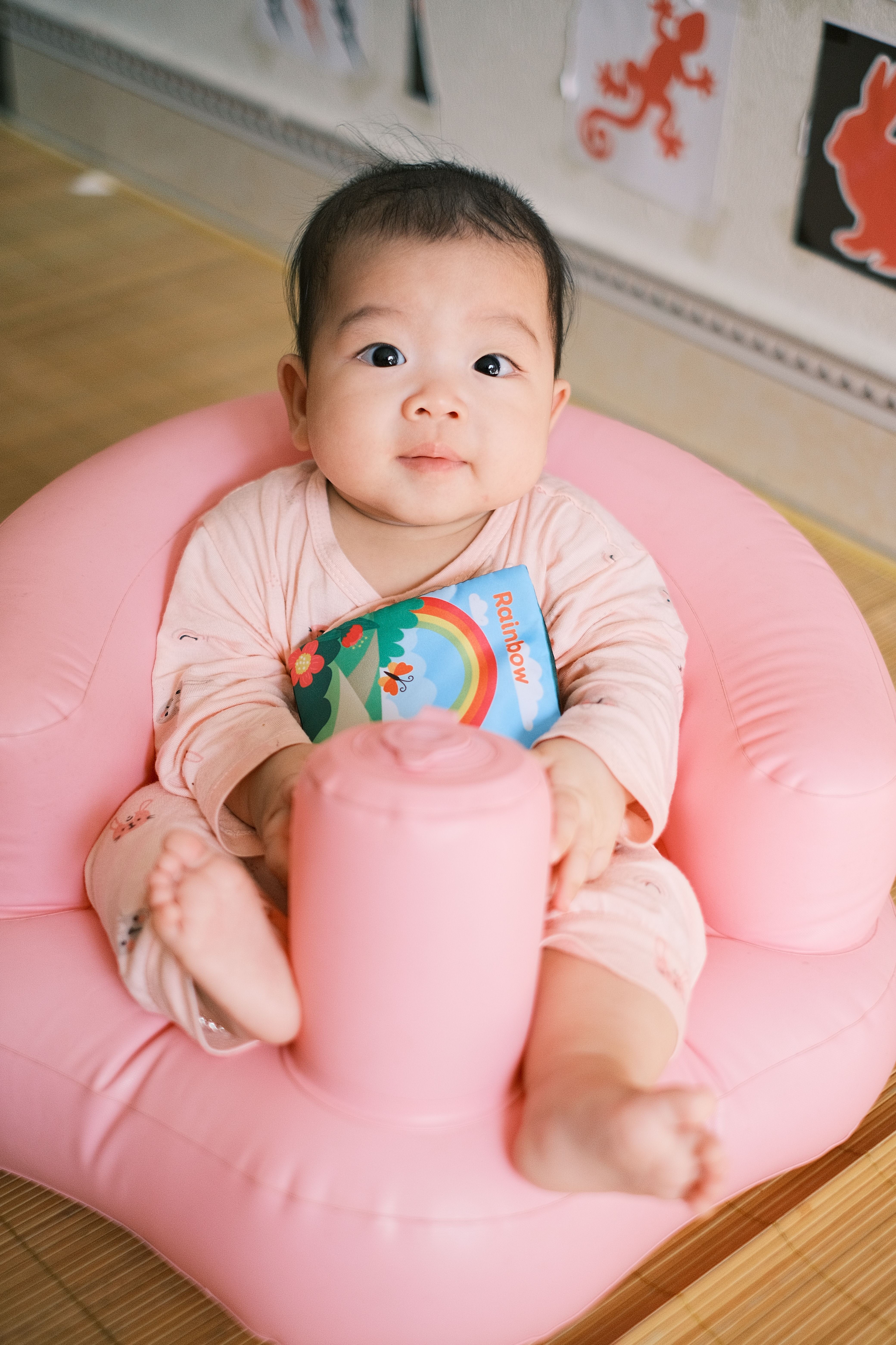 Adorable Baby in Inflatable Chair Reading Book · Free Stock Photo