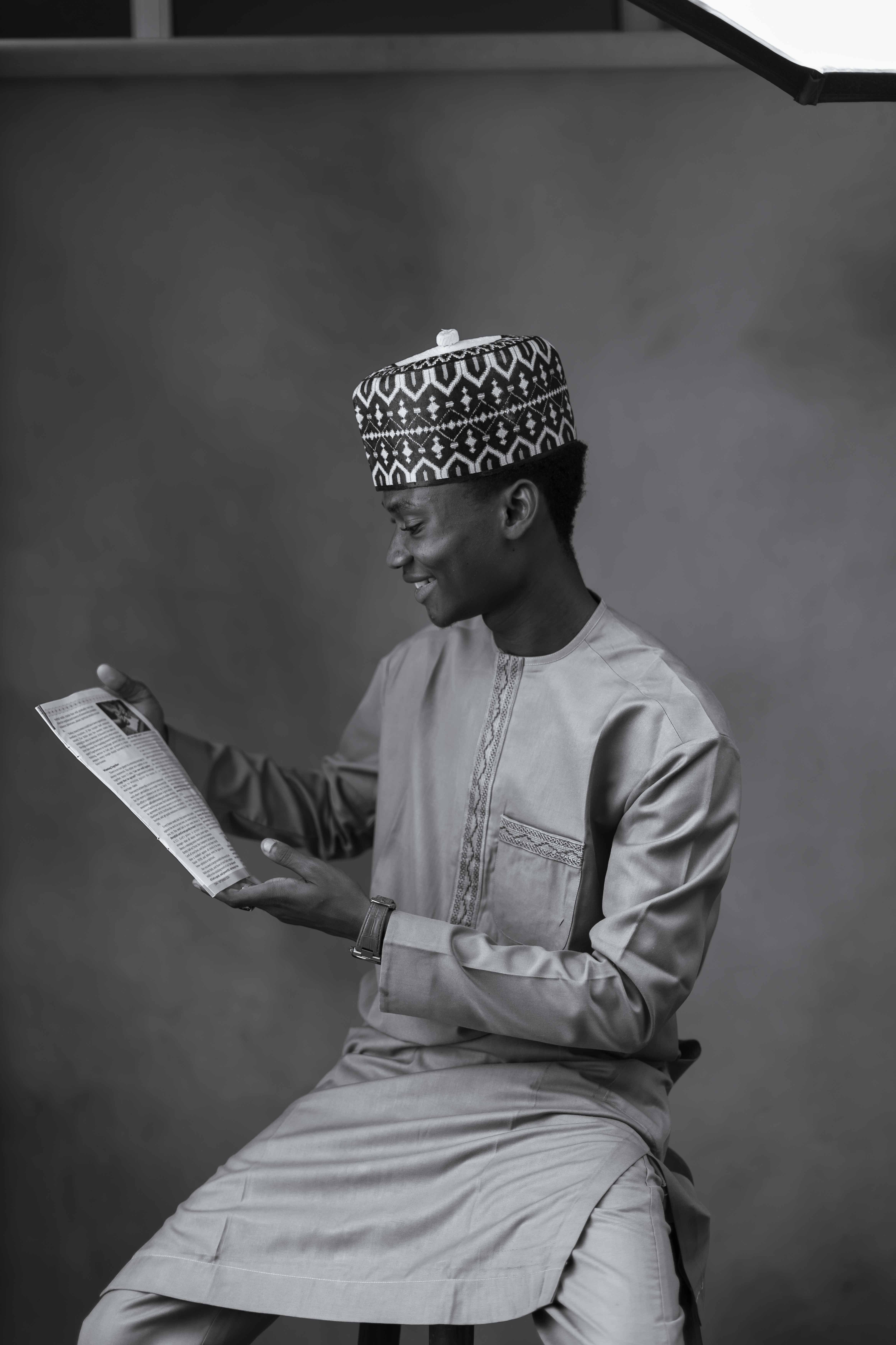 Young Man in Traditional Nigerian Attire Reading · Free Stock Photo