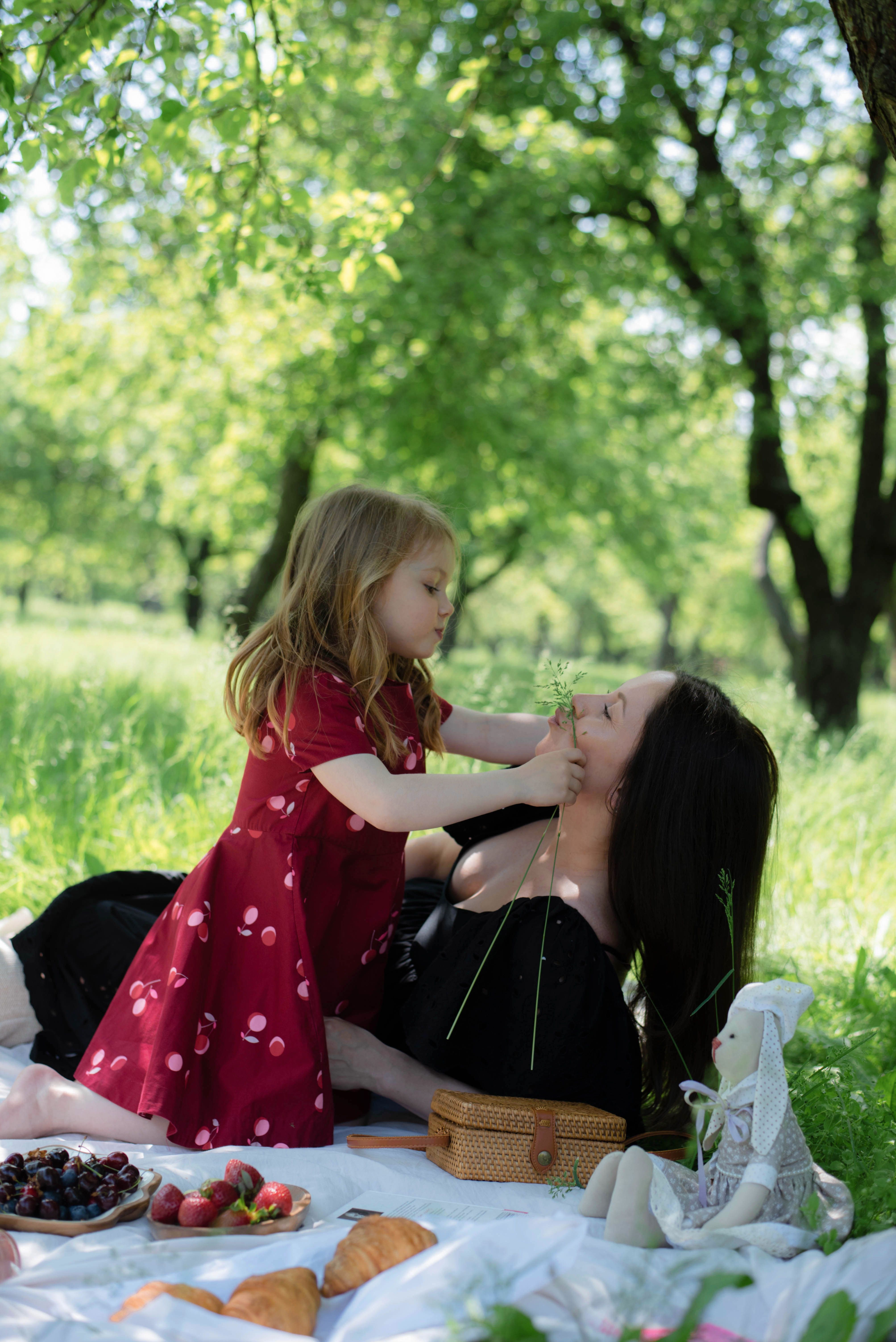 Mother and Daughter Picnic in a Lush Orchard · Free Stock Photo