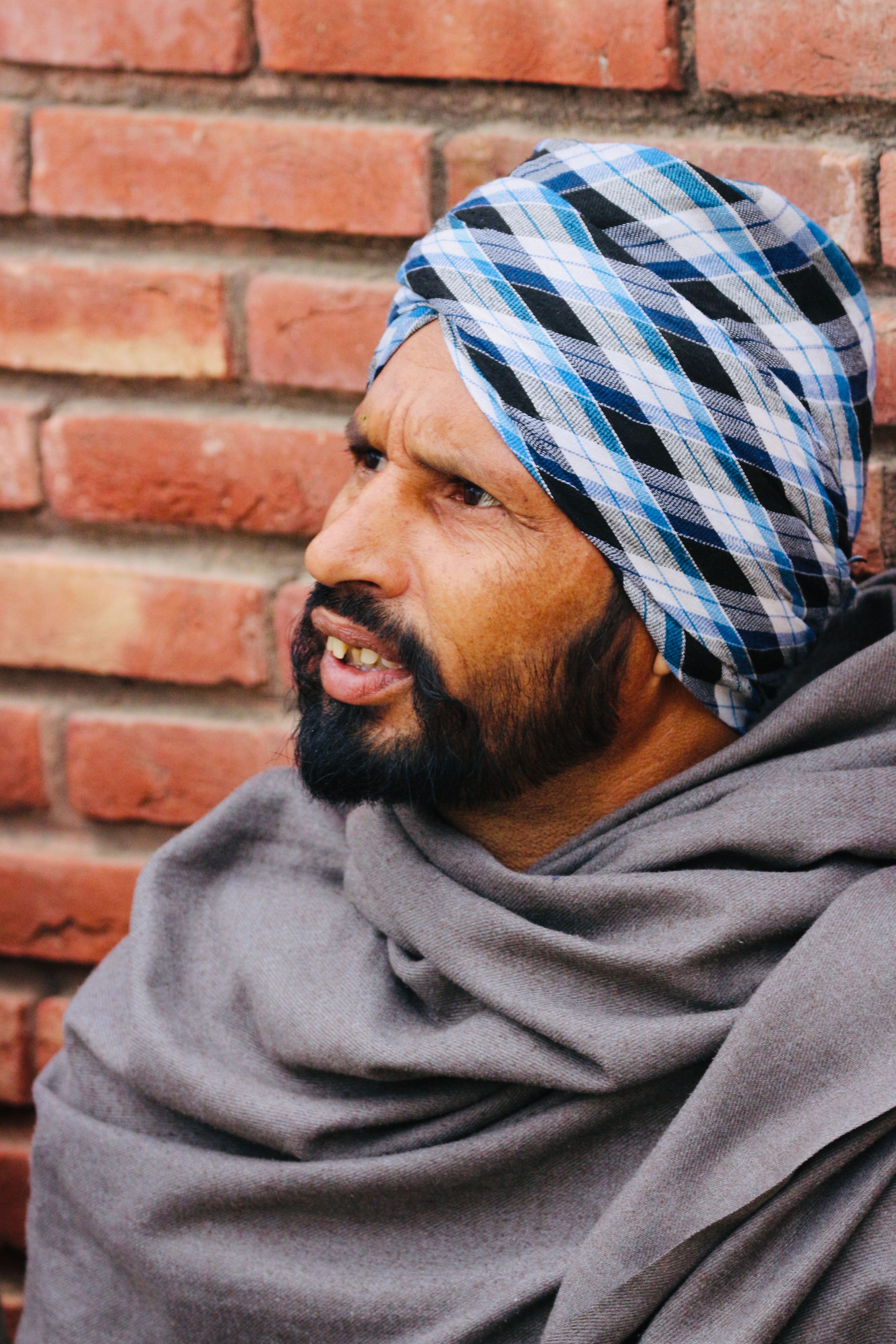 Portrait of a Man in a Turban Against Brick Wall · Free Stock Photo