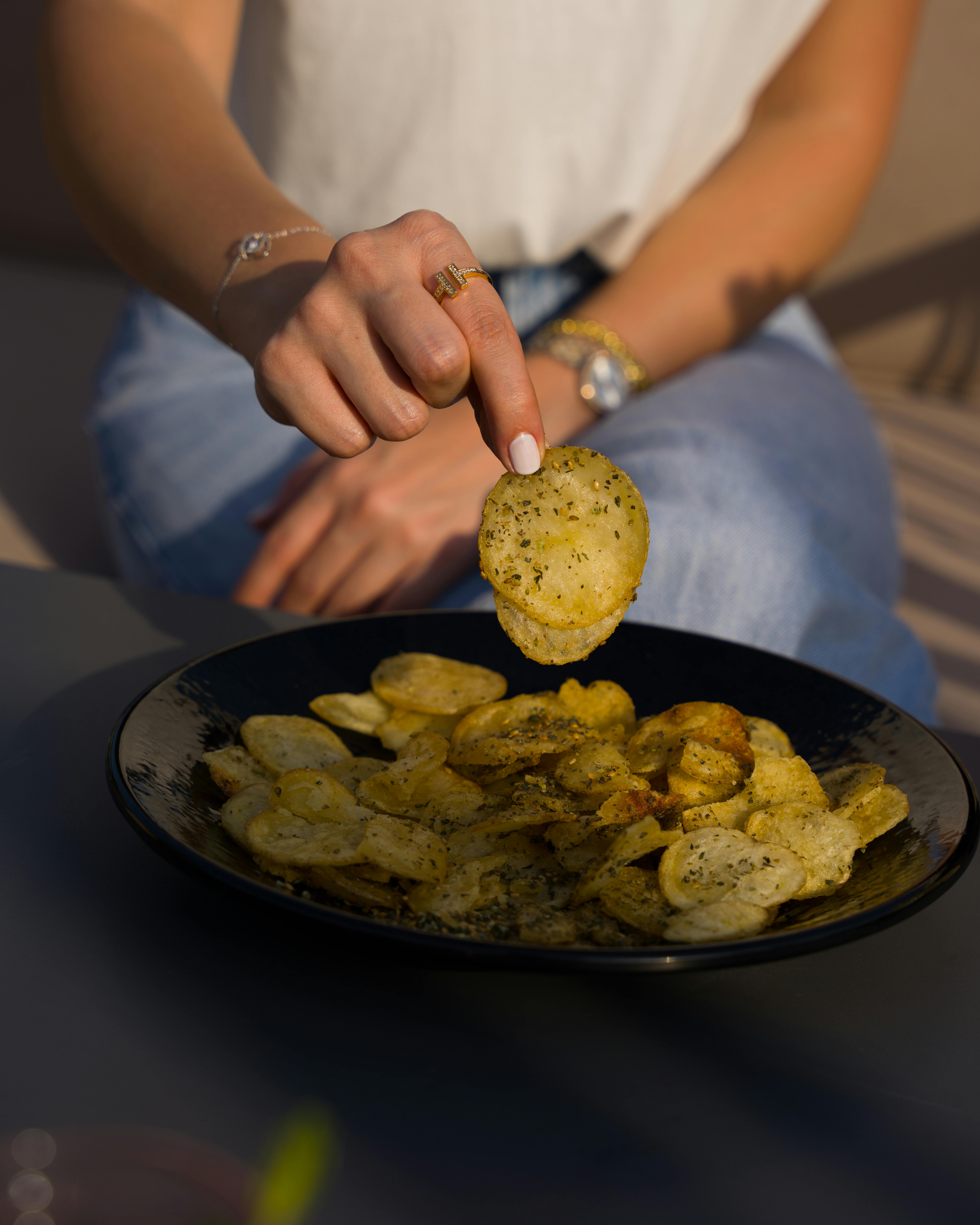 Close-up of hand holding seasoned potato chip · Free Stock Photo