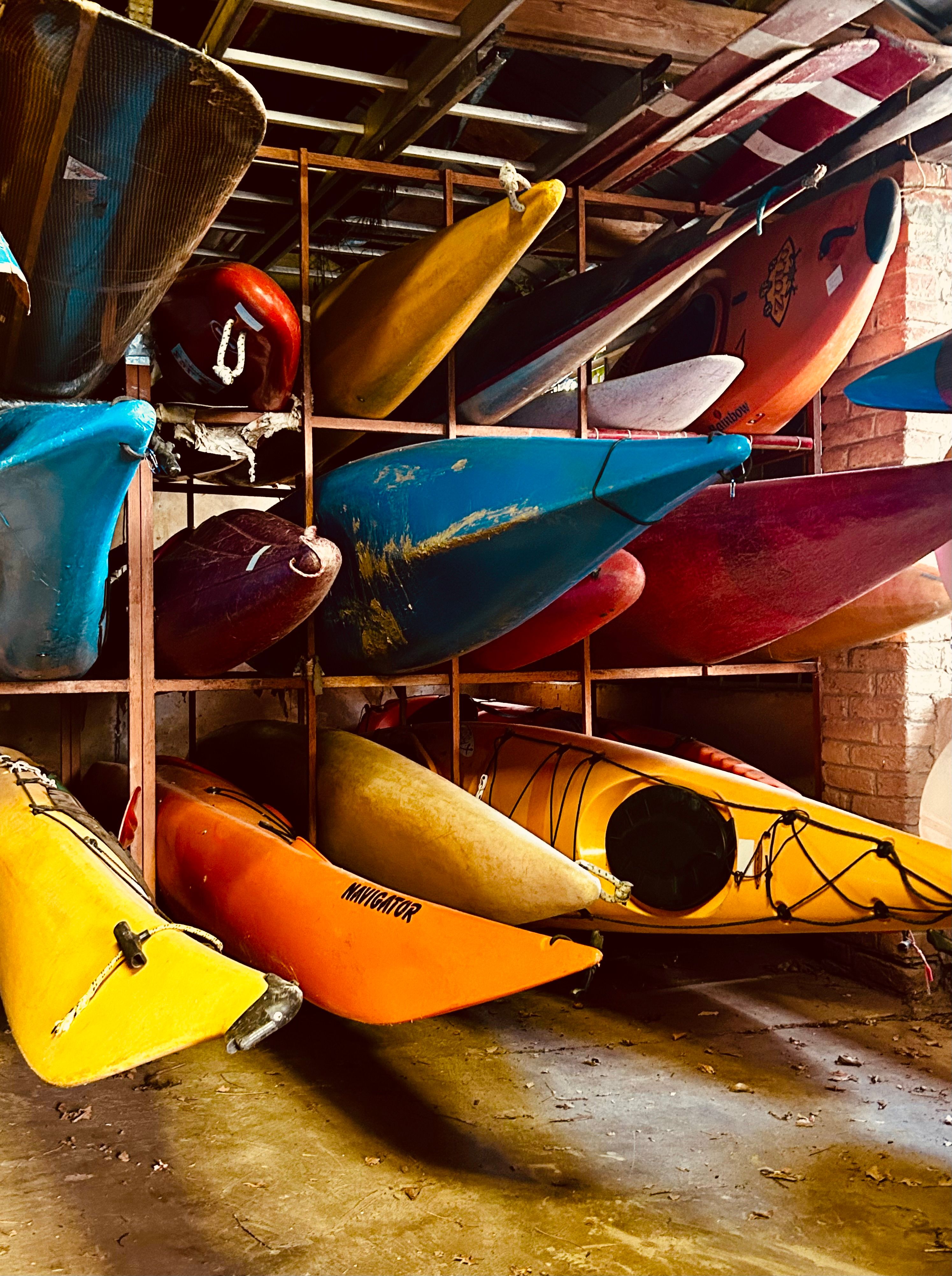 Colorful Kayaks Stored in Rustic Warehouse · Free Stock Photo
