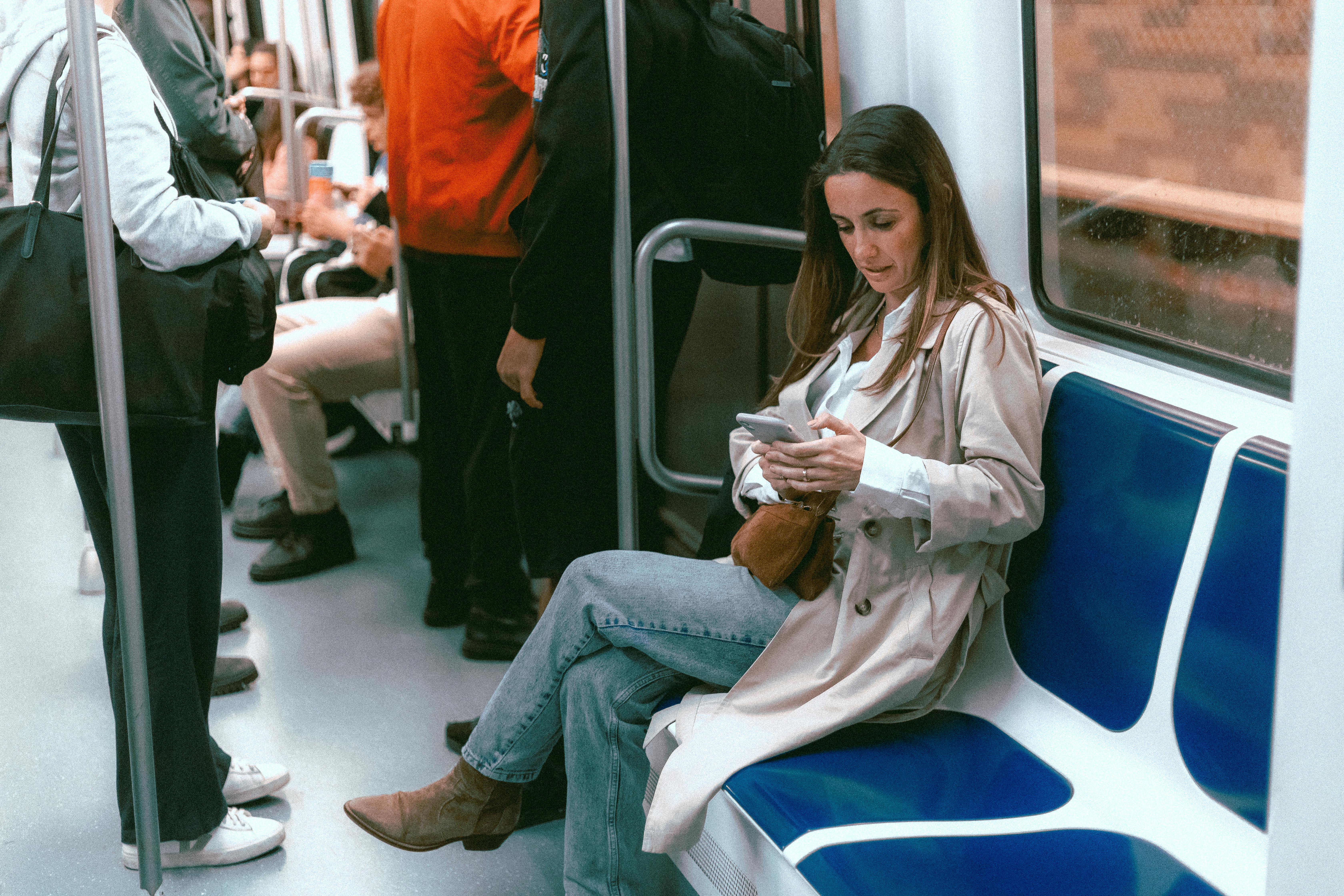 Woman on Subway Using Smartphone in Casual Outfit · Free Stock Photo