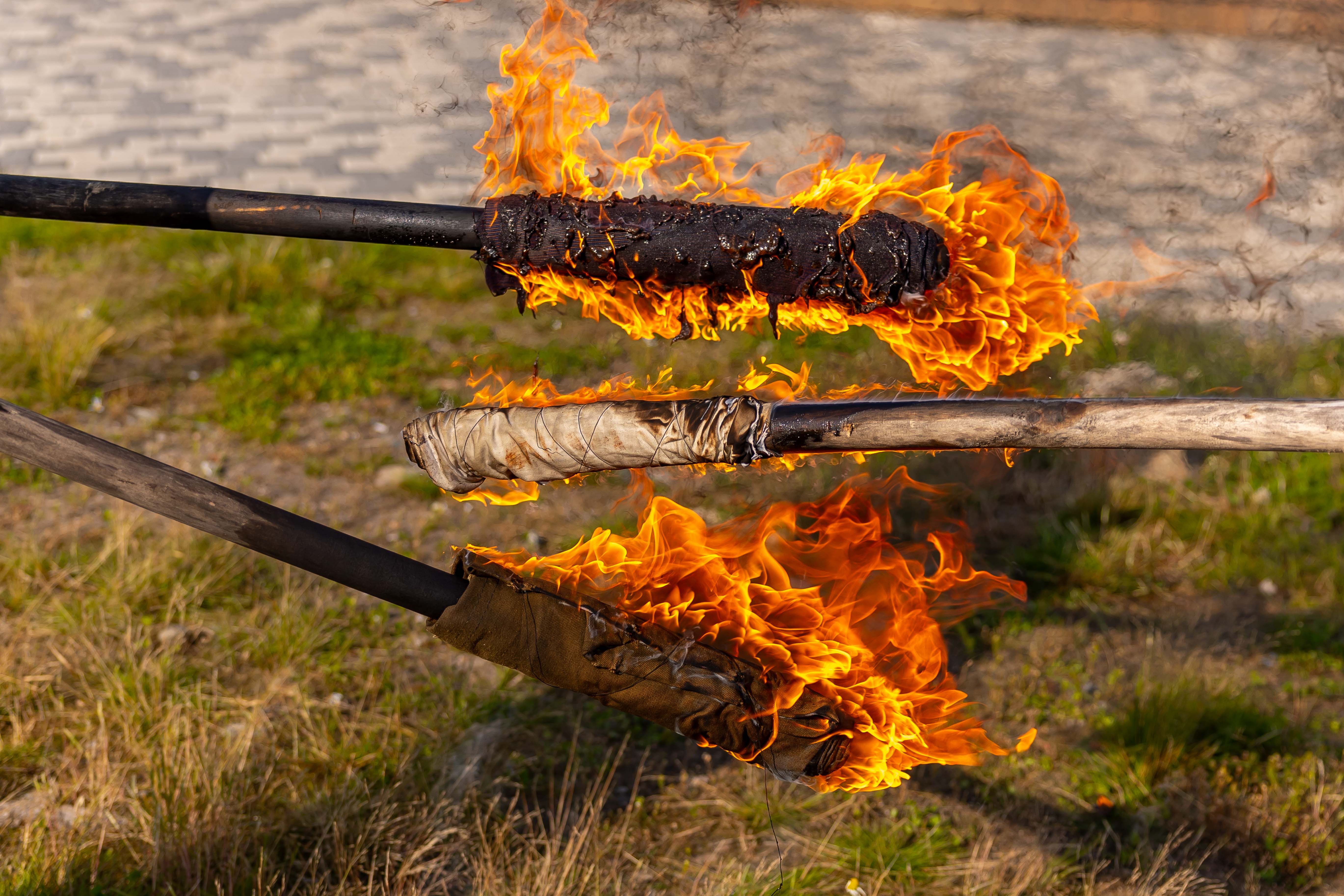 Burning Wooden Torches in Outdoor Setting · Free Stock Photo