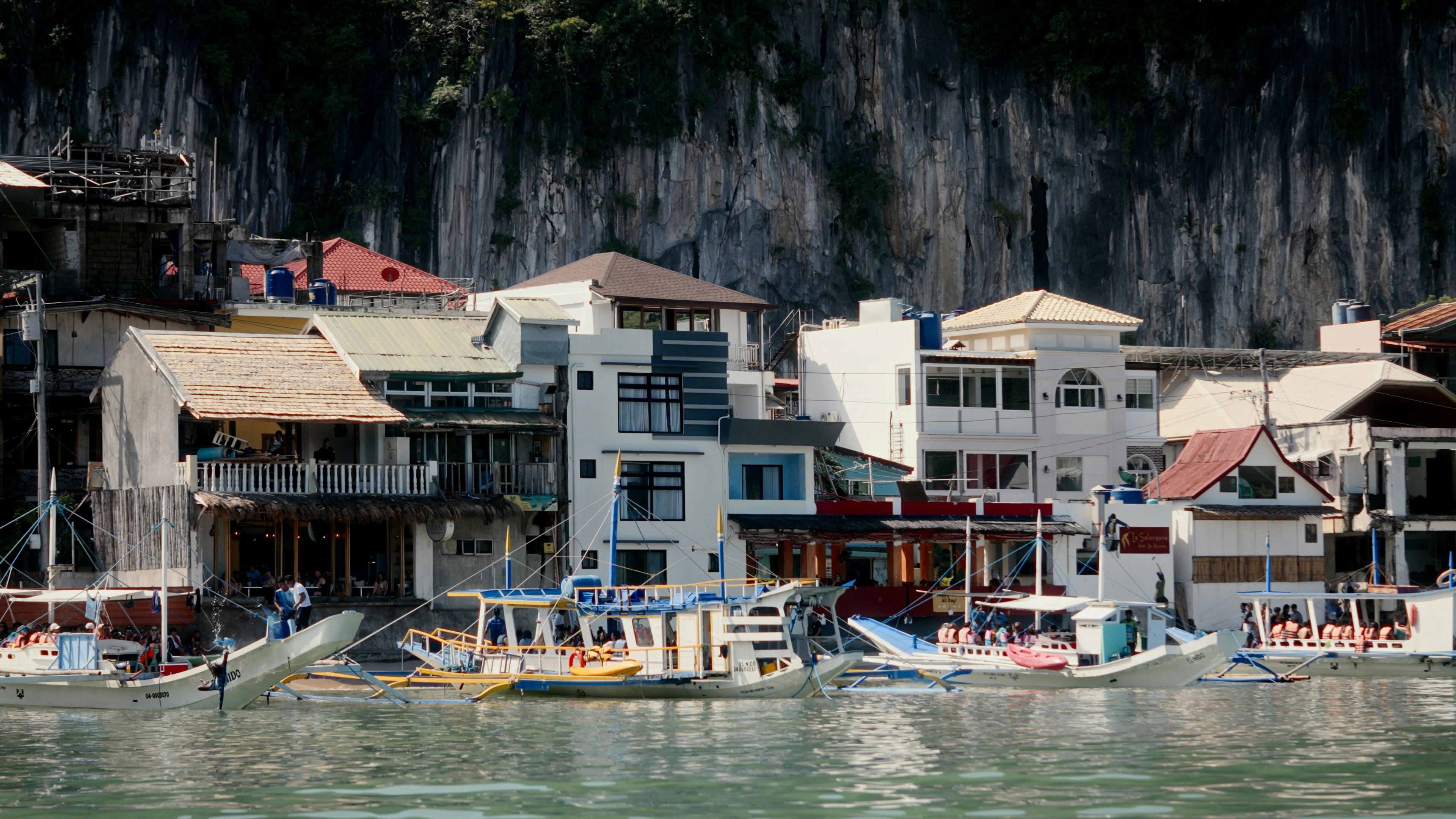 Colorful Boats and Waterfront Houses in Scenic Harbor · Free Stock Photo