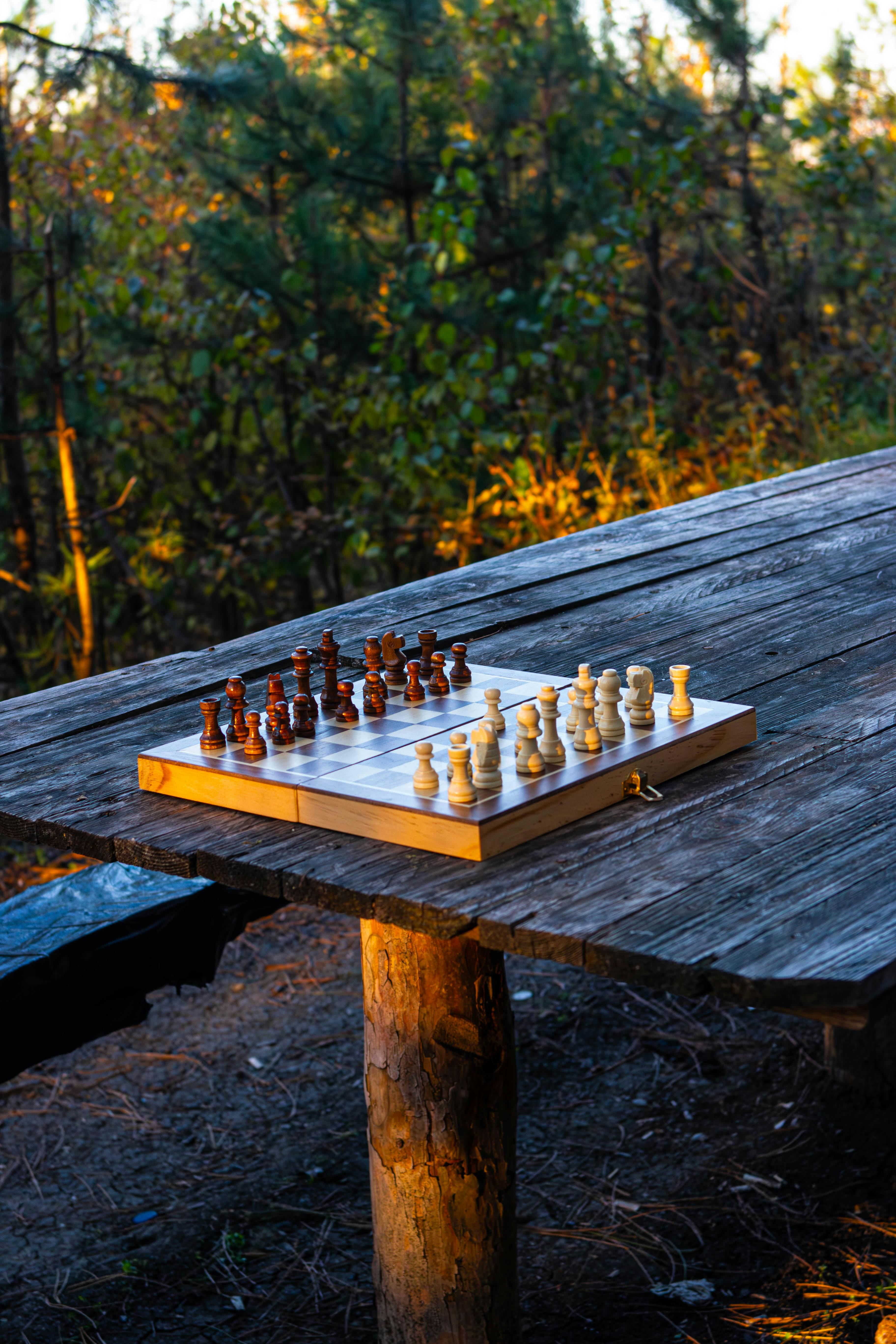 Outdoor Chess Game on Rustic Wooden Table · Free Stock Photo