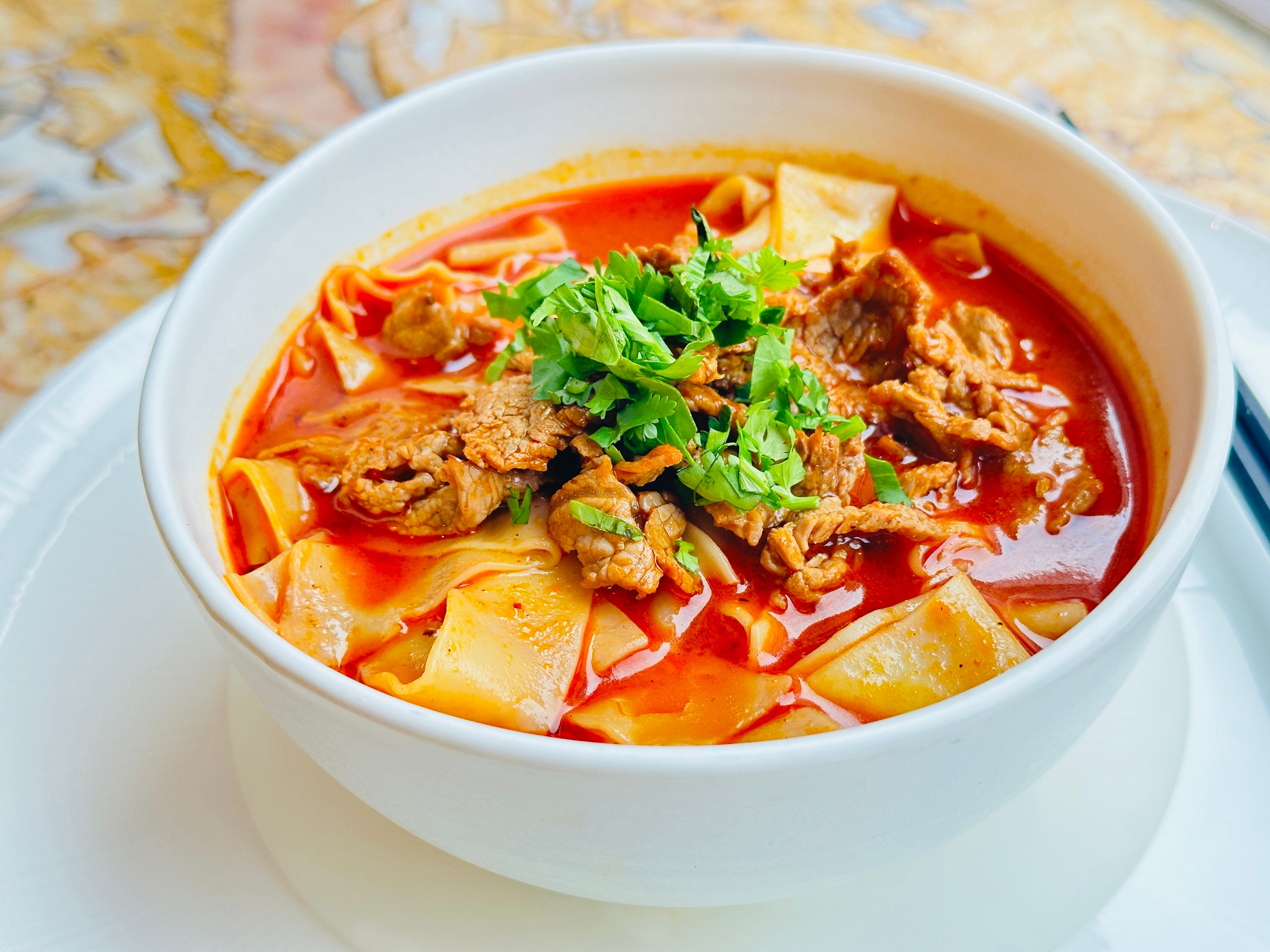 Spicy Lamb Noodle Soup in White Bowl on Marble Table · Free Stock Photo