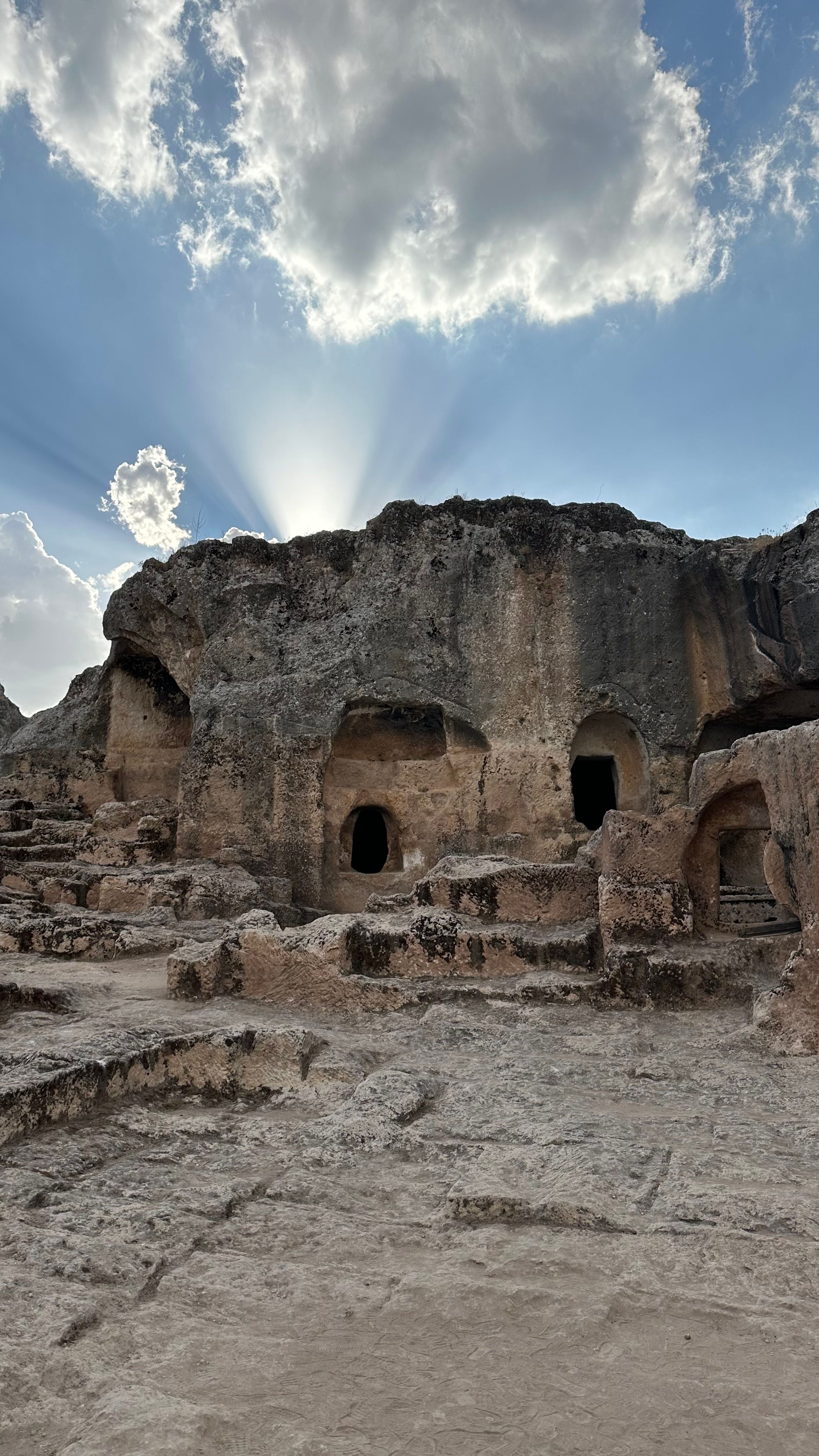 Ancient cave dwellings under dramatic sky · Free Stock Photo