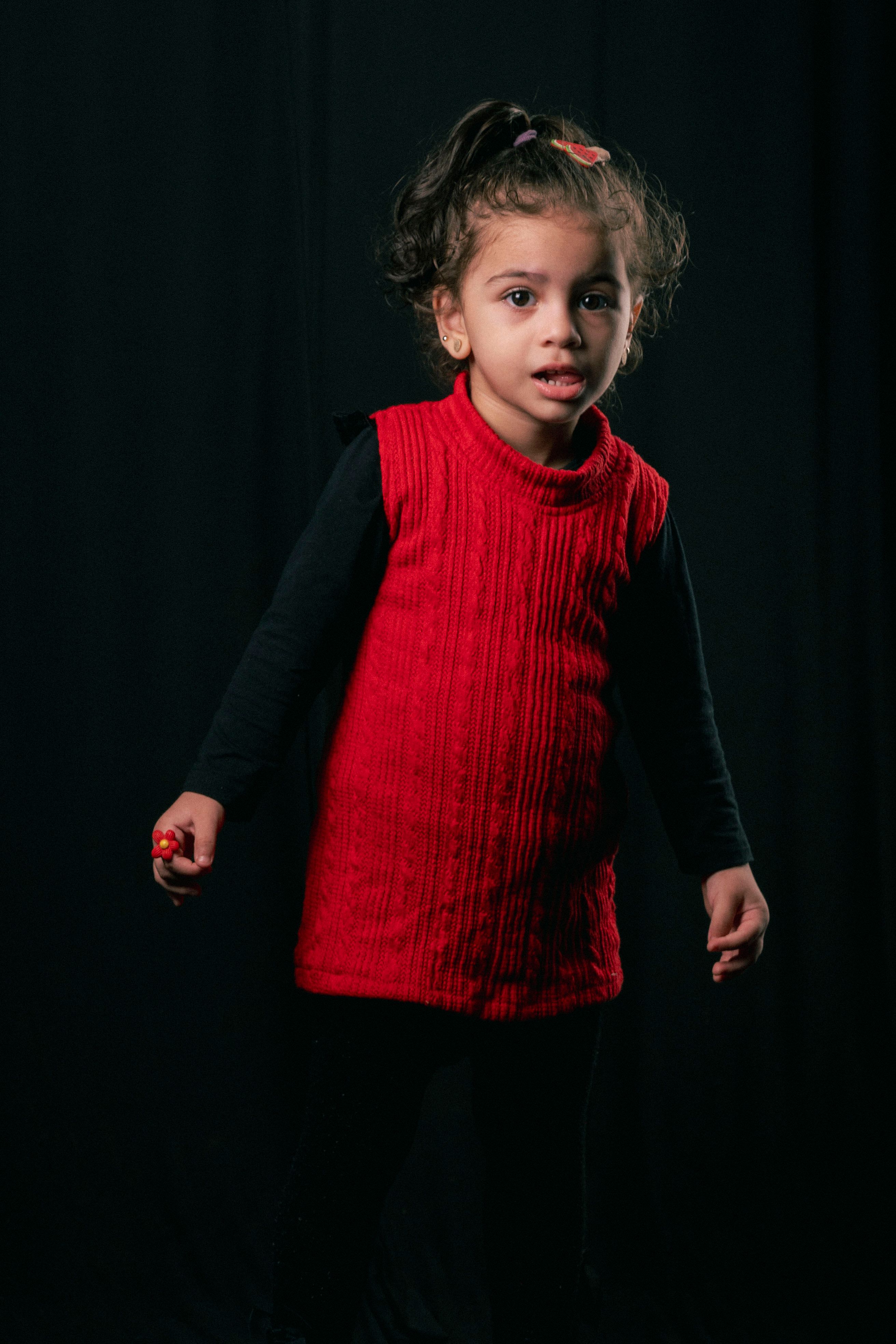 Young Child in Red Dress on Dark Background · Free Stock Photo