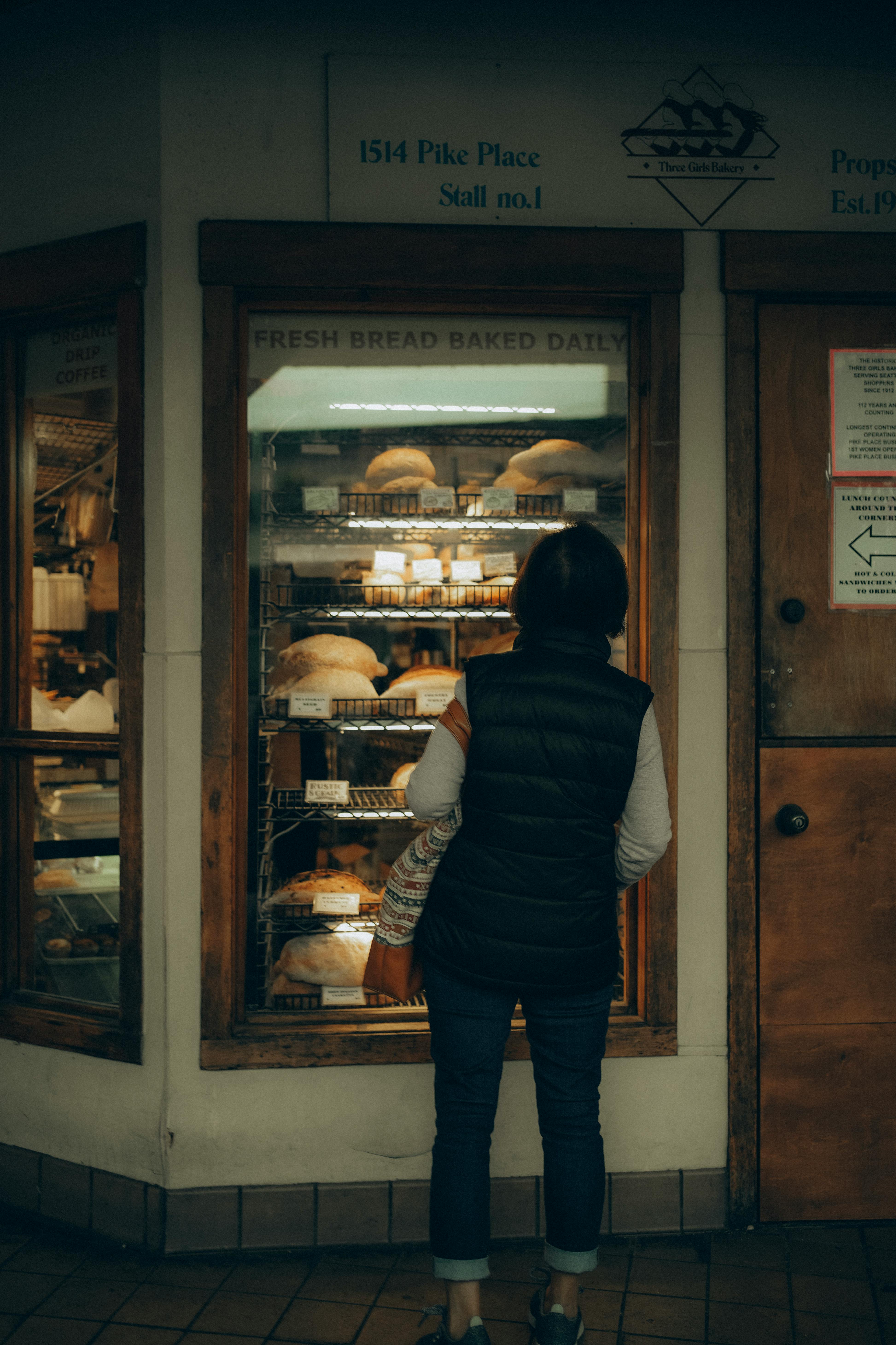 Customer Browses Artisan Bread in Seattle Bakery · Free Stock Photo
