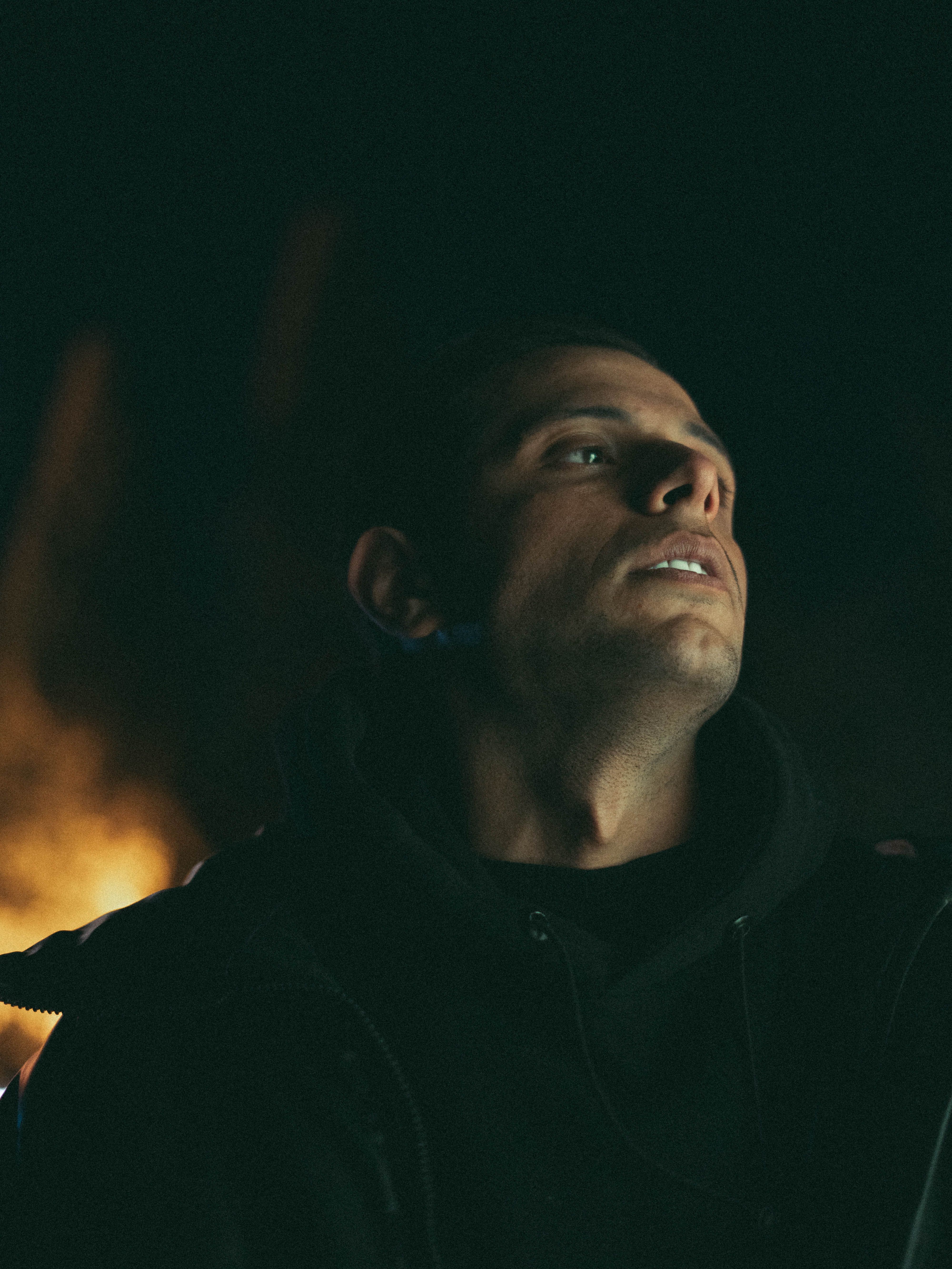 Contemplative Man in Dramatic Lighting at Night · Free Stock Photo