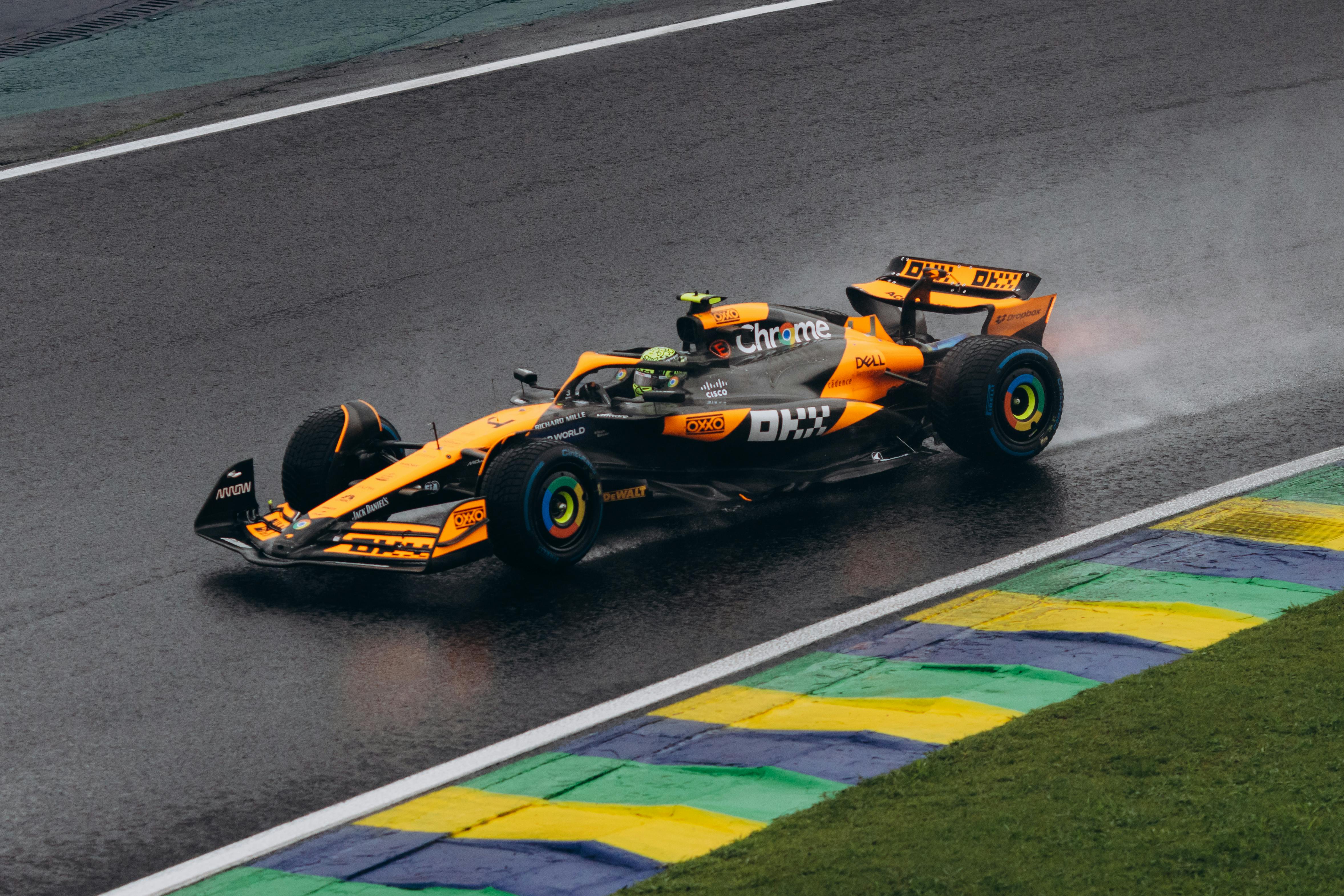 High-Speed Formula One Car Racing on Wet Track · Free Stock Photo