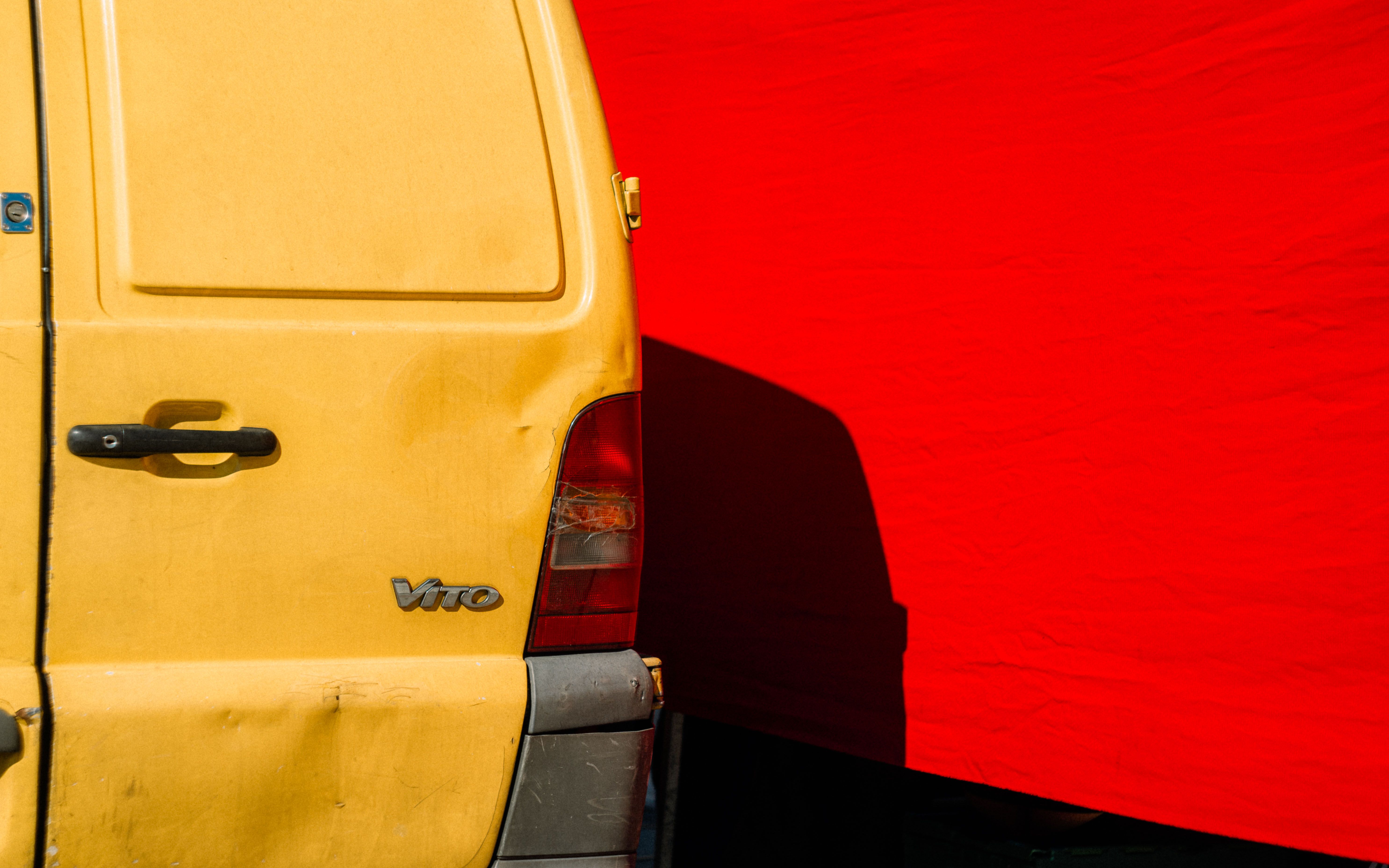 Yellow Van Against Bright Red Background in Madrid · Free Stock Photo