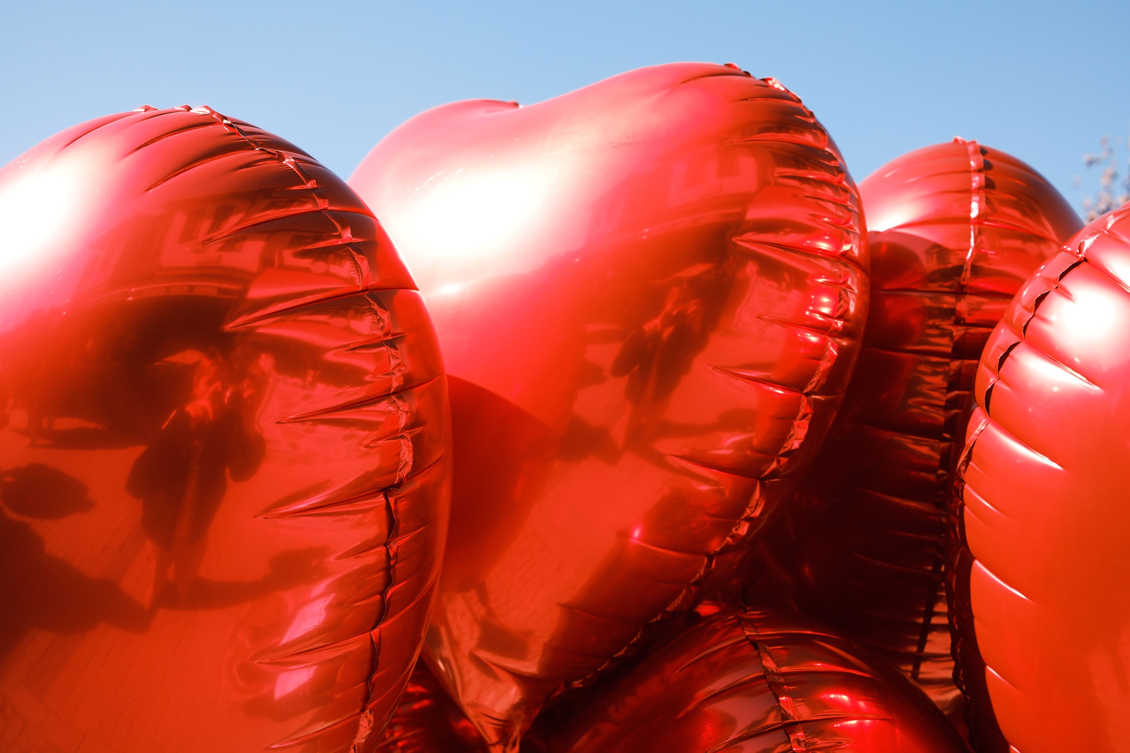 Bright Red Heart Balloons against Clear Sky · Free Stock Photo