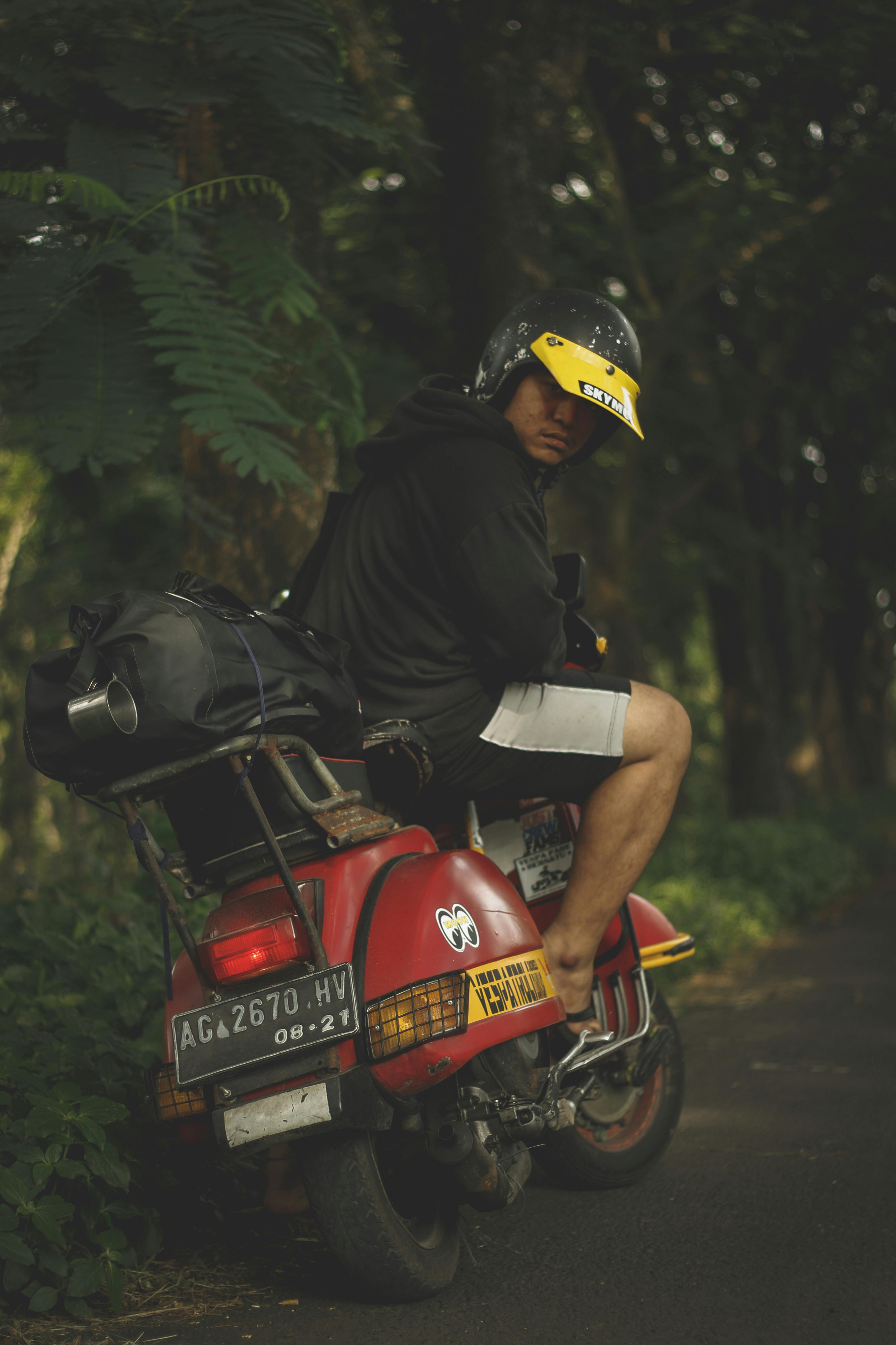 Shallow Focus Photo of Person Riding Red Motor Scooter · Free Stock Photo