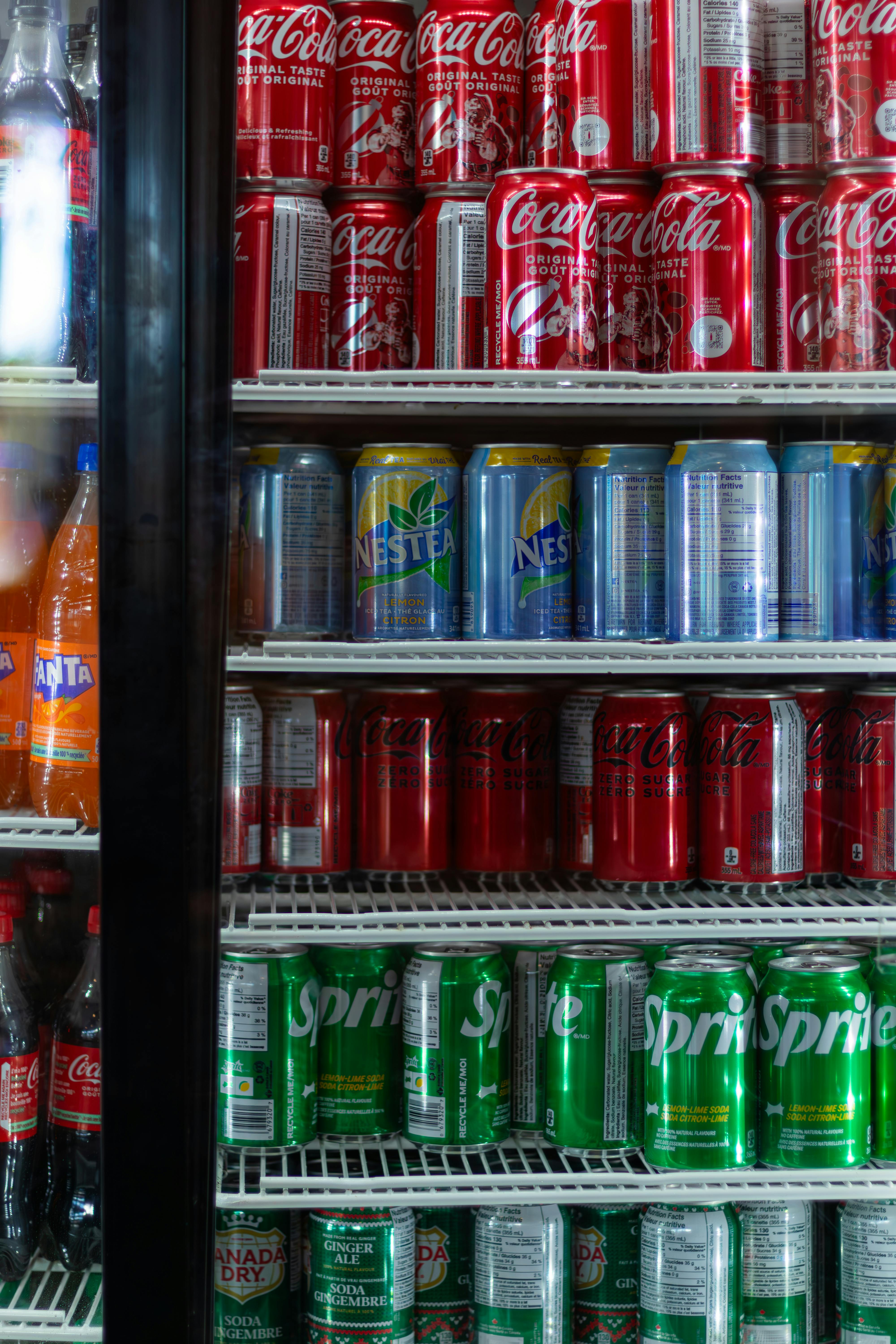 Assorted Soda Cans in Refrigerator Display · Free Stock Photo