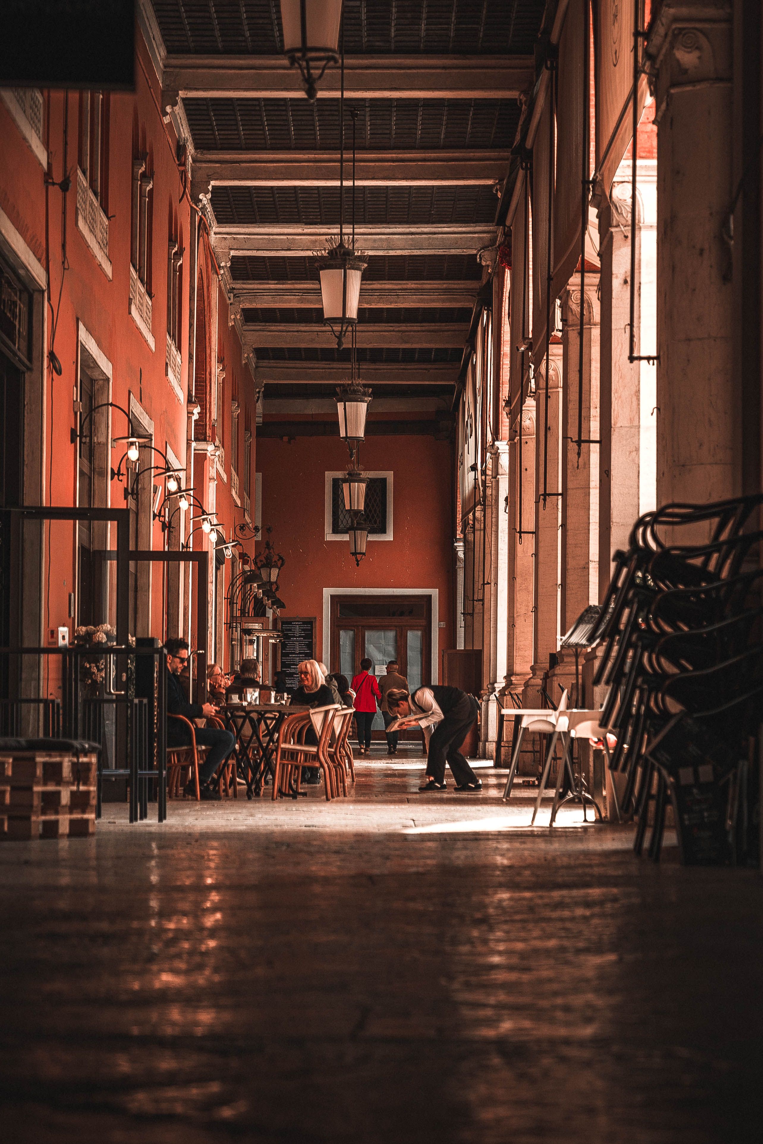 Charming Outdoor Café in a Sunlit Corridor · Free Stock Photo