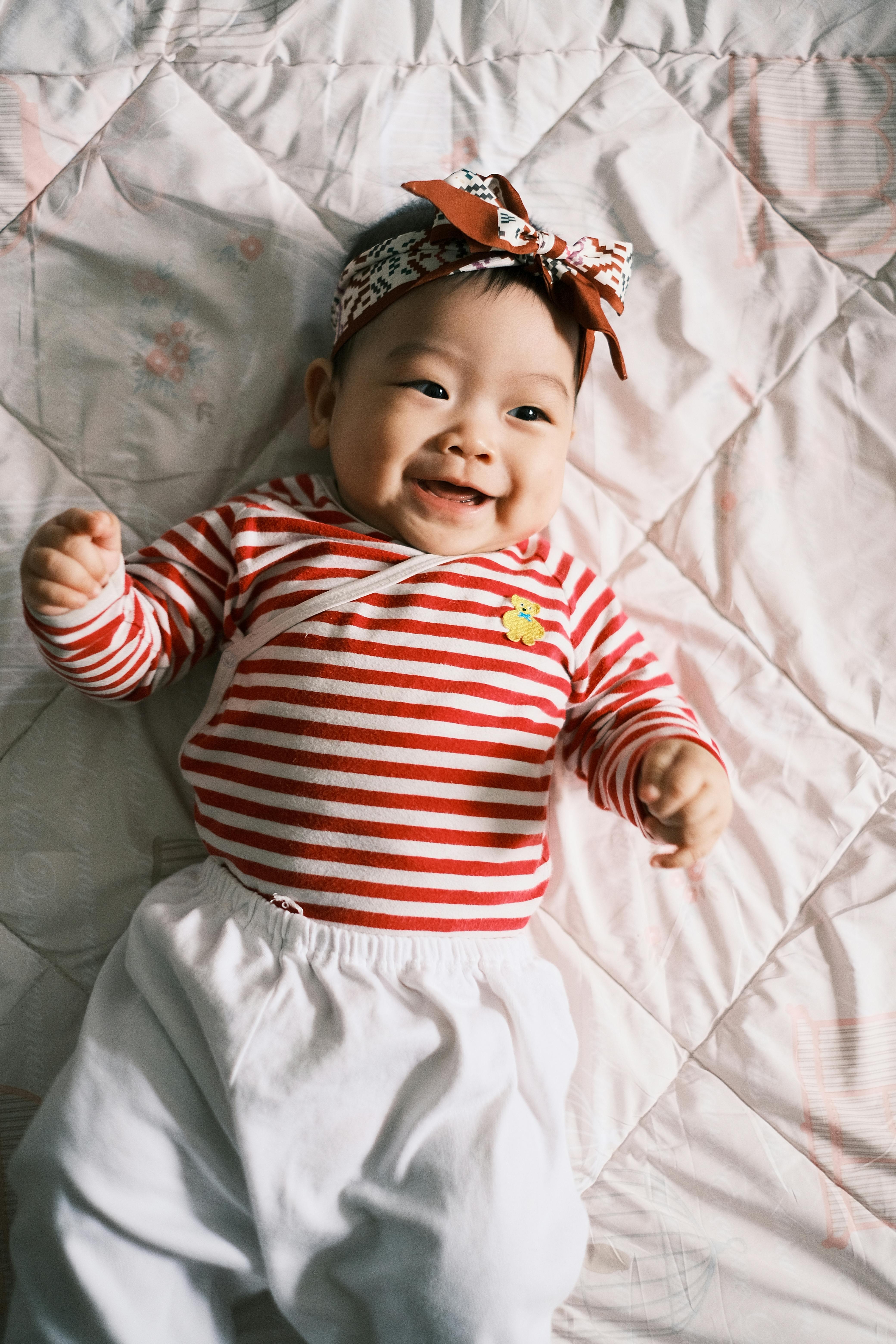 Happy Baby in Red Stripe Outfit on Soft Blanket · Free Stock Photo