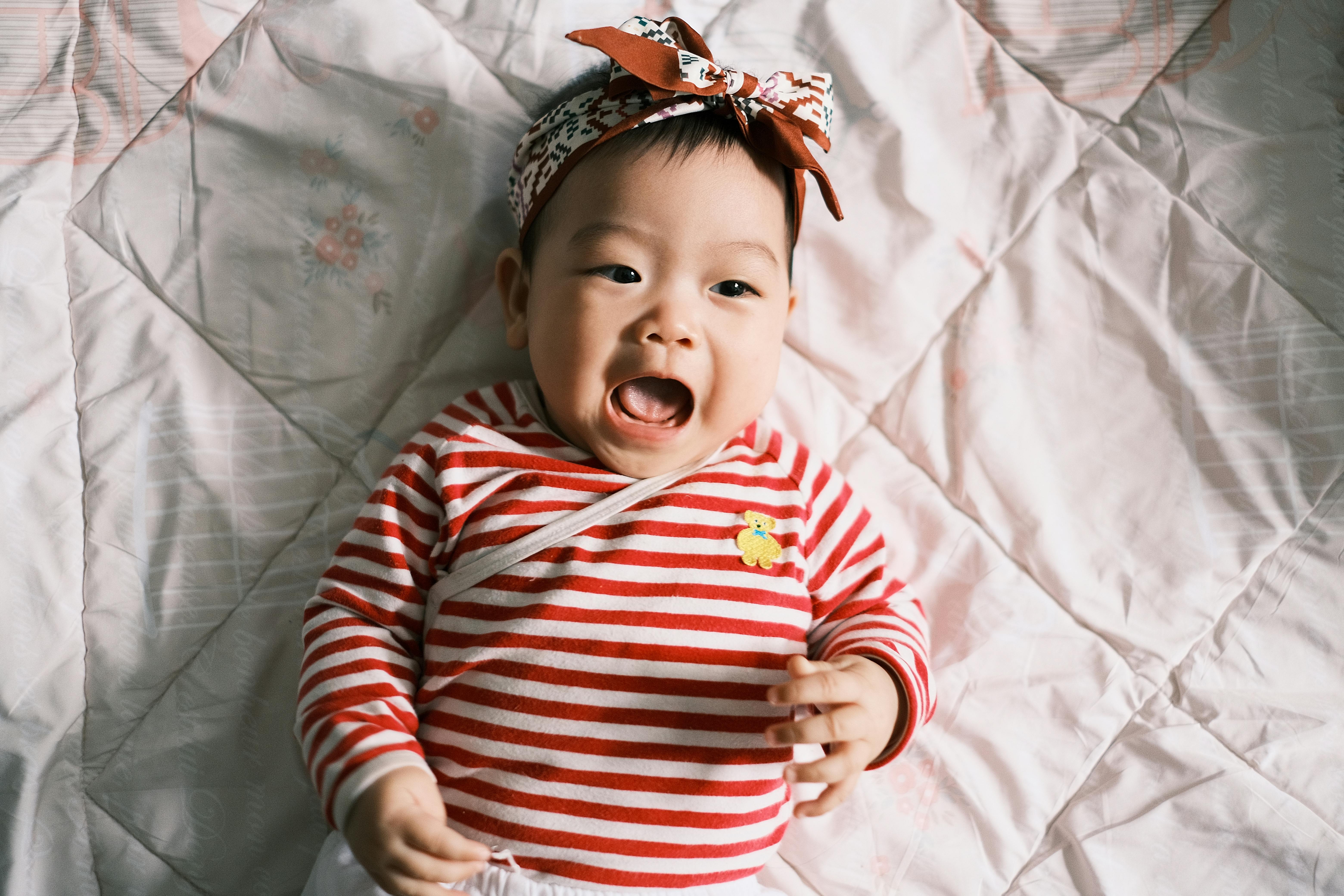 Adorable Baby Girl in Striped Outfit on Blanket · Free Stock Photo