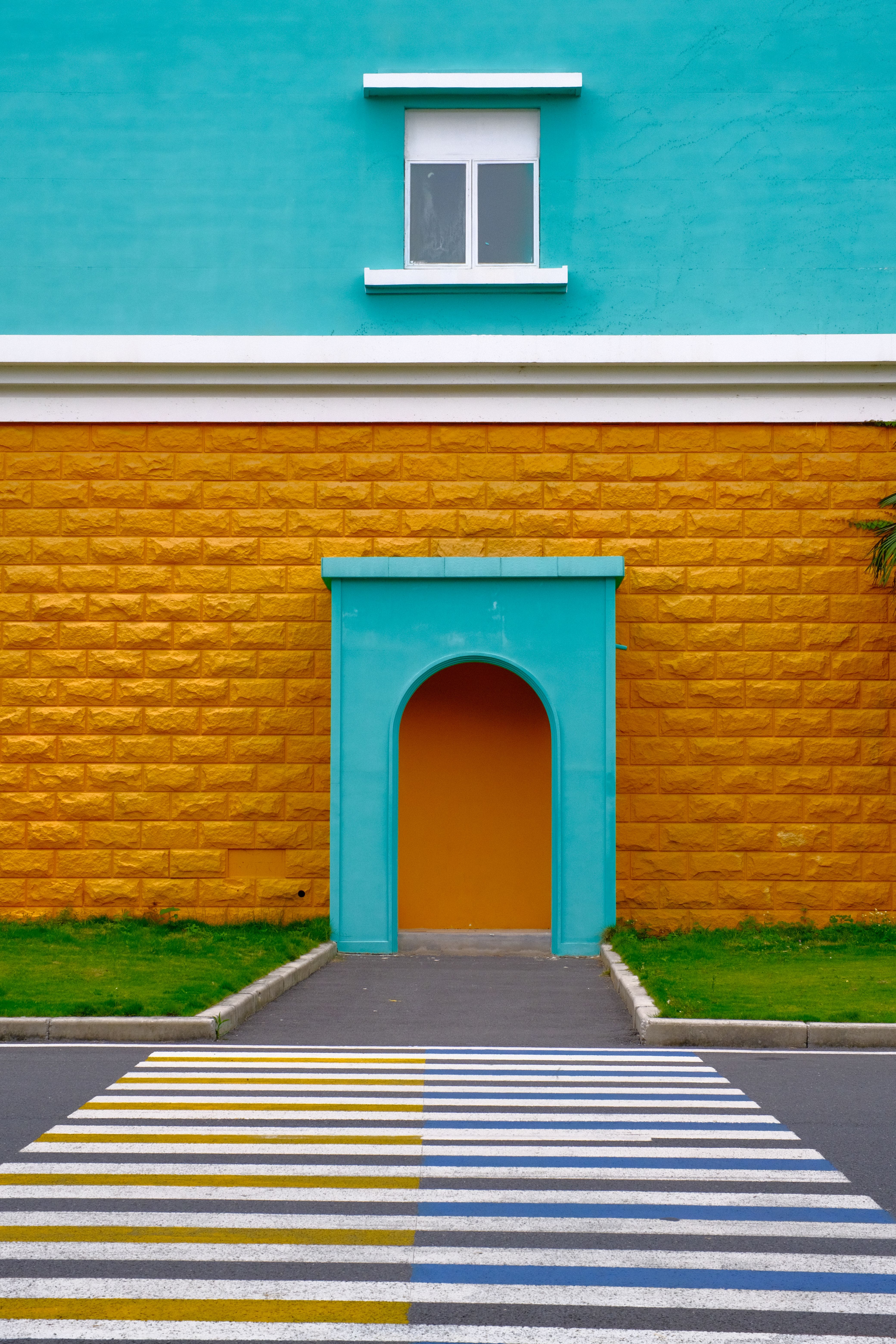 Colorful Urban Building Facade with Striped Crosswalk · Free Stock Photo