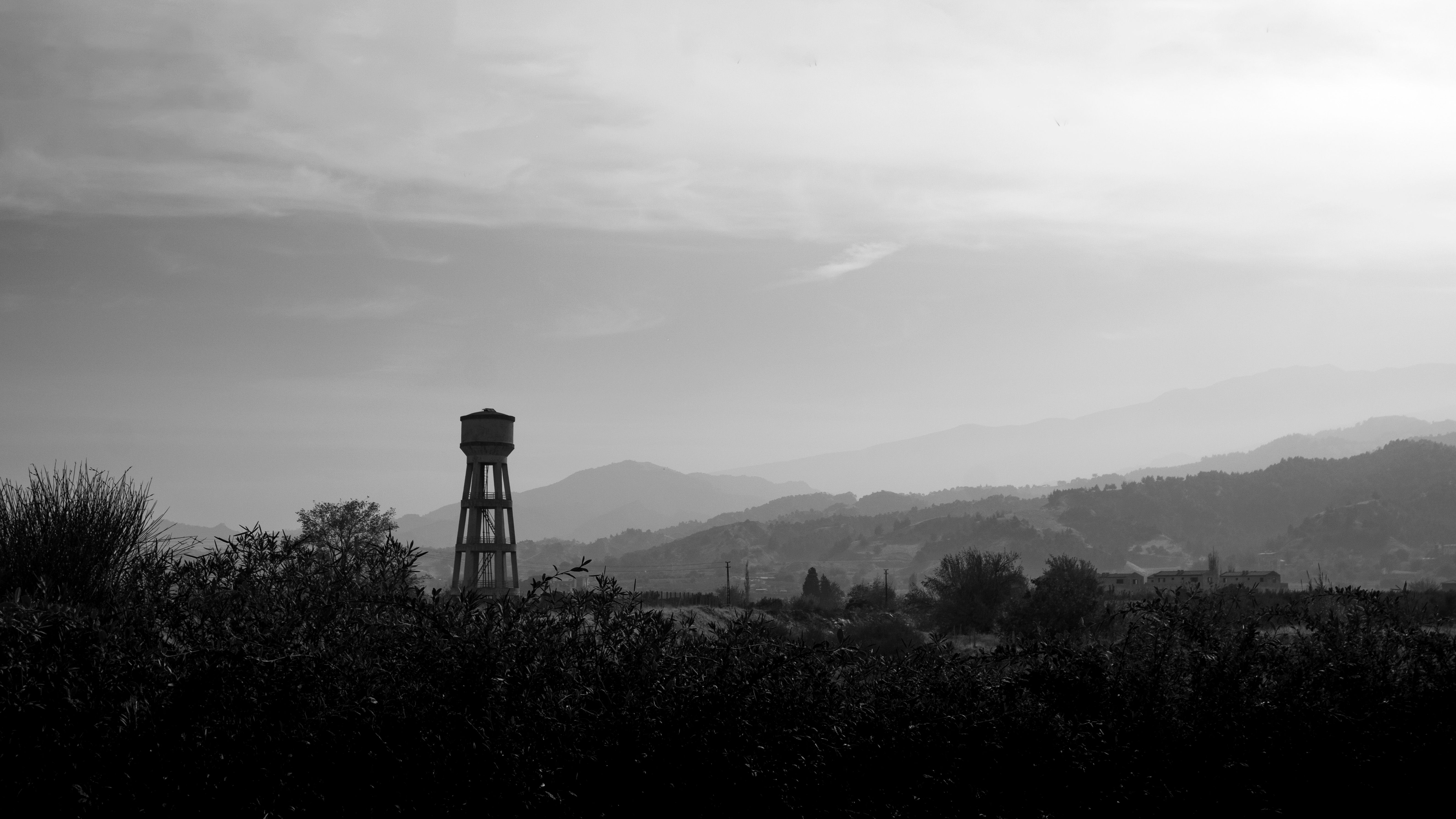 Black and White Water Tower in Scenic Landscape · Free Stock Photo