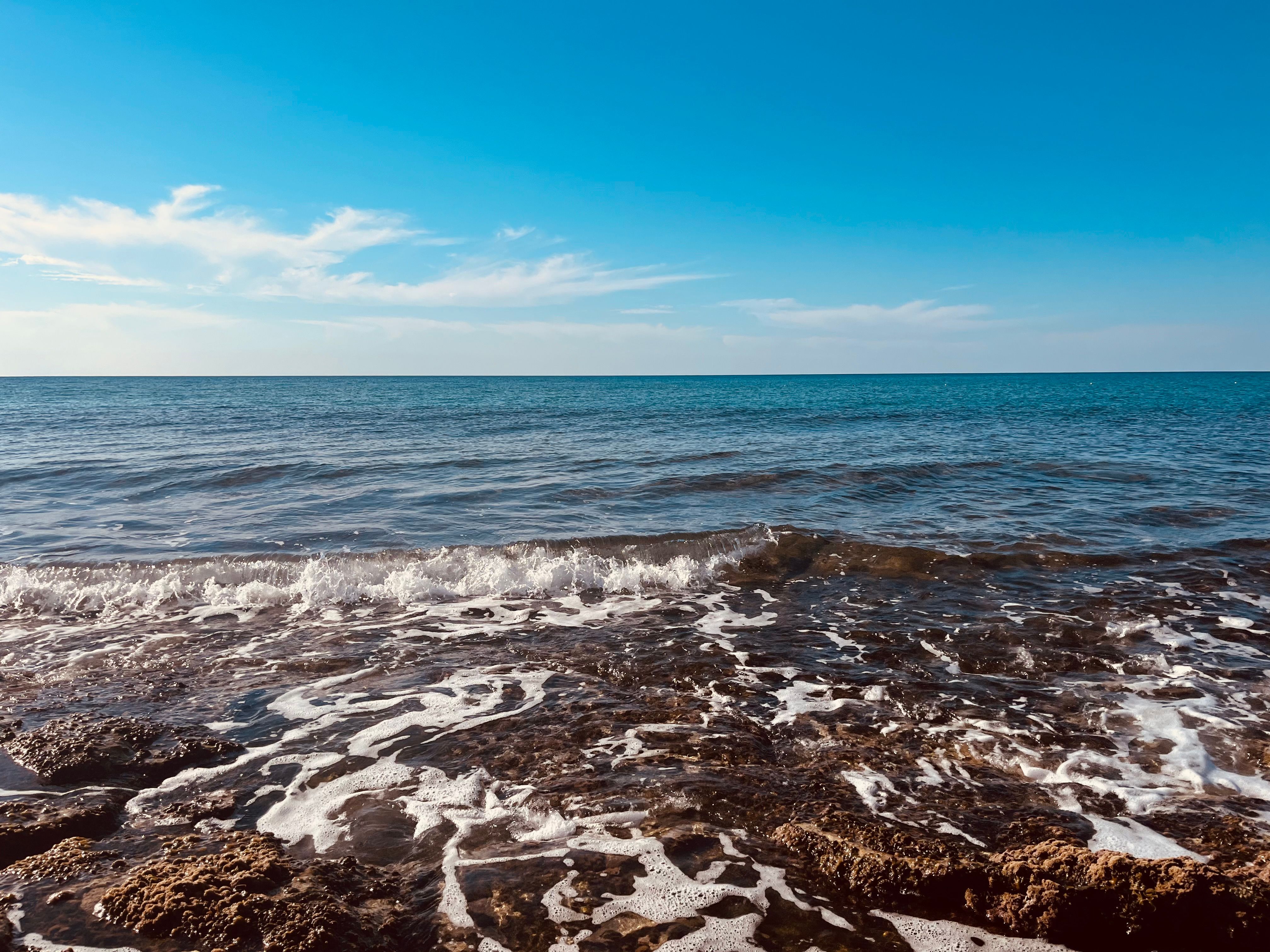Serene Ocean Waves Along Rocky Shoreline · Free Stock Photo