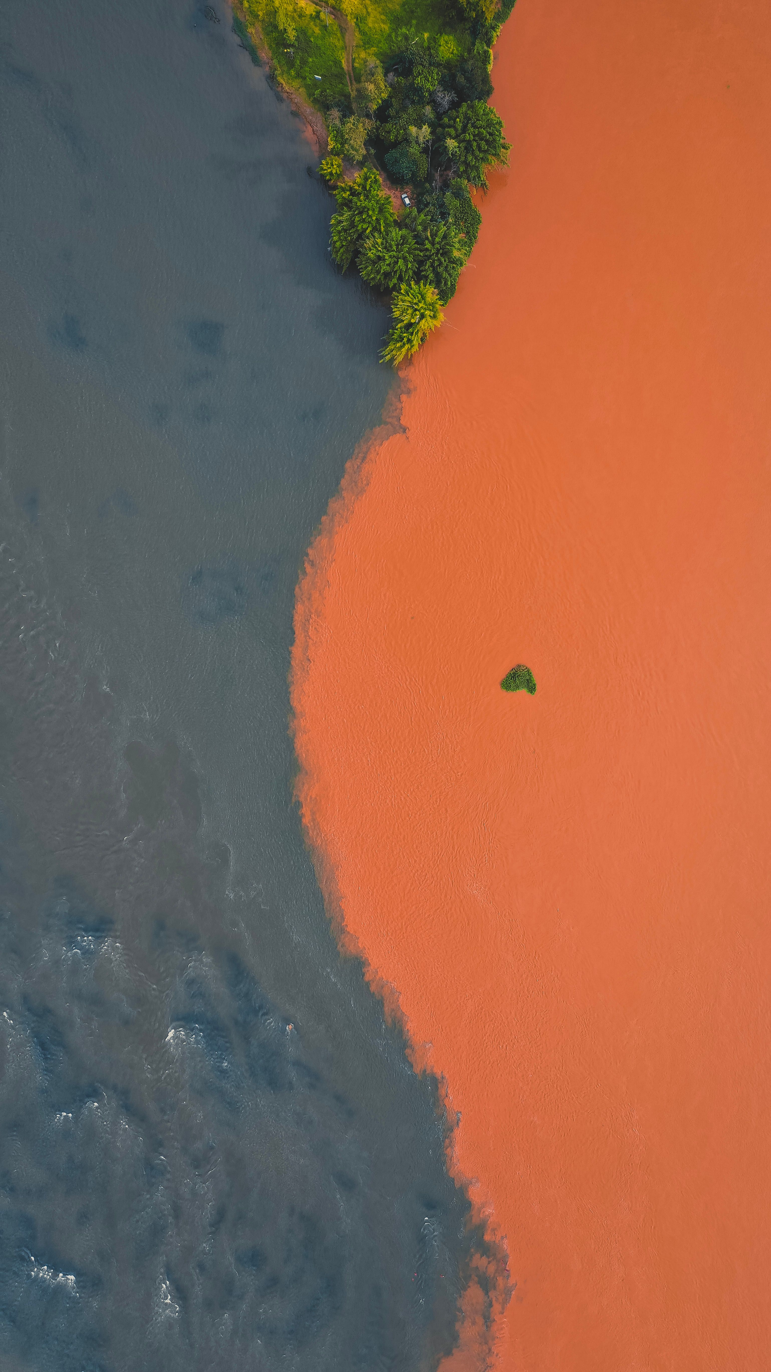 Aerial View of River Confluence with Red and Blue Waters · Free Stock Photo