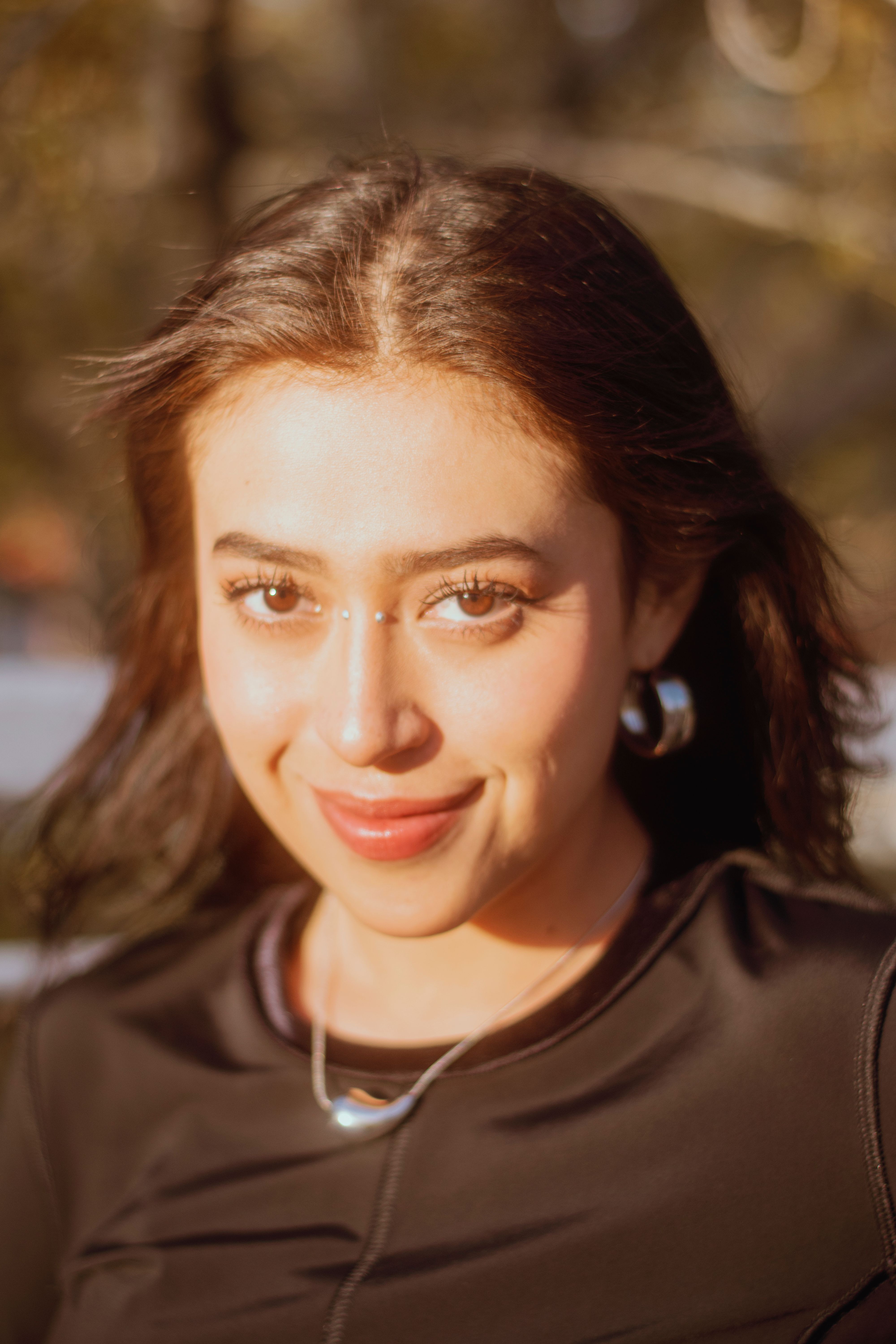 Warm Portrait of a Smiling Woman Outdoors · Free Stock Photo