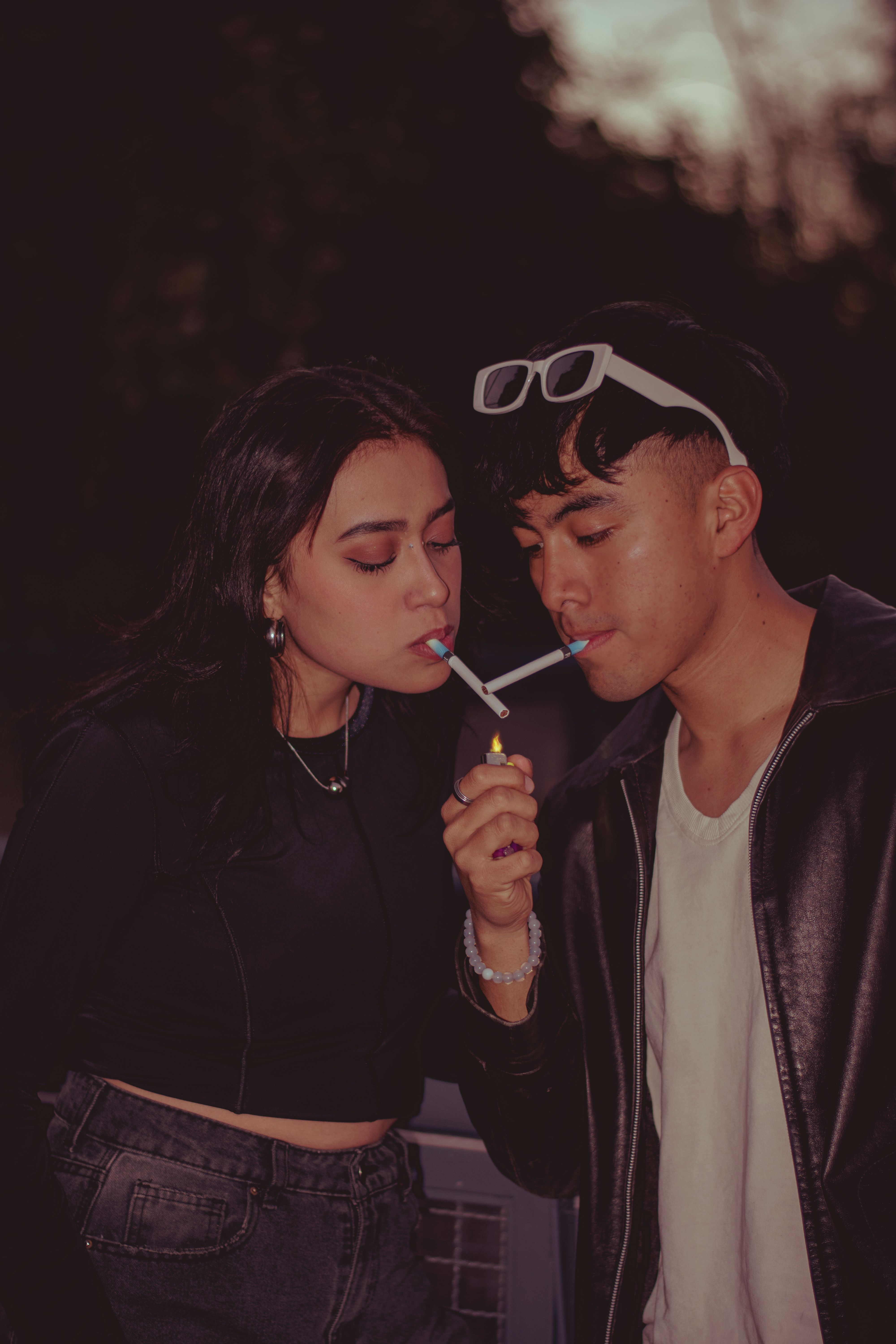 Young Adults Smoking Outdoors at Twilight · Free Stock Photo