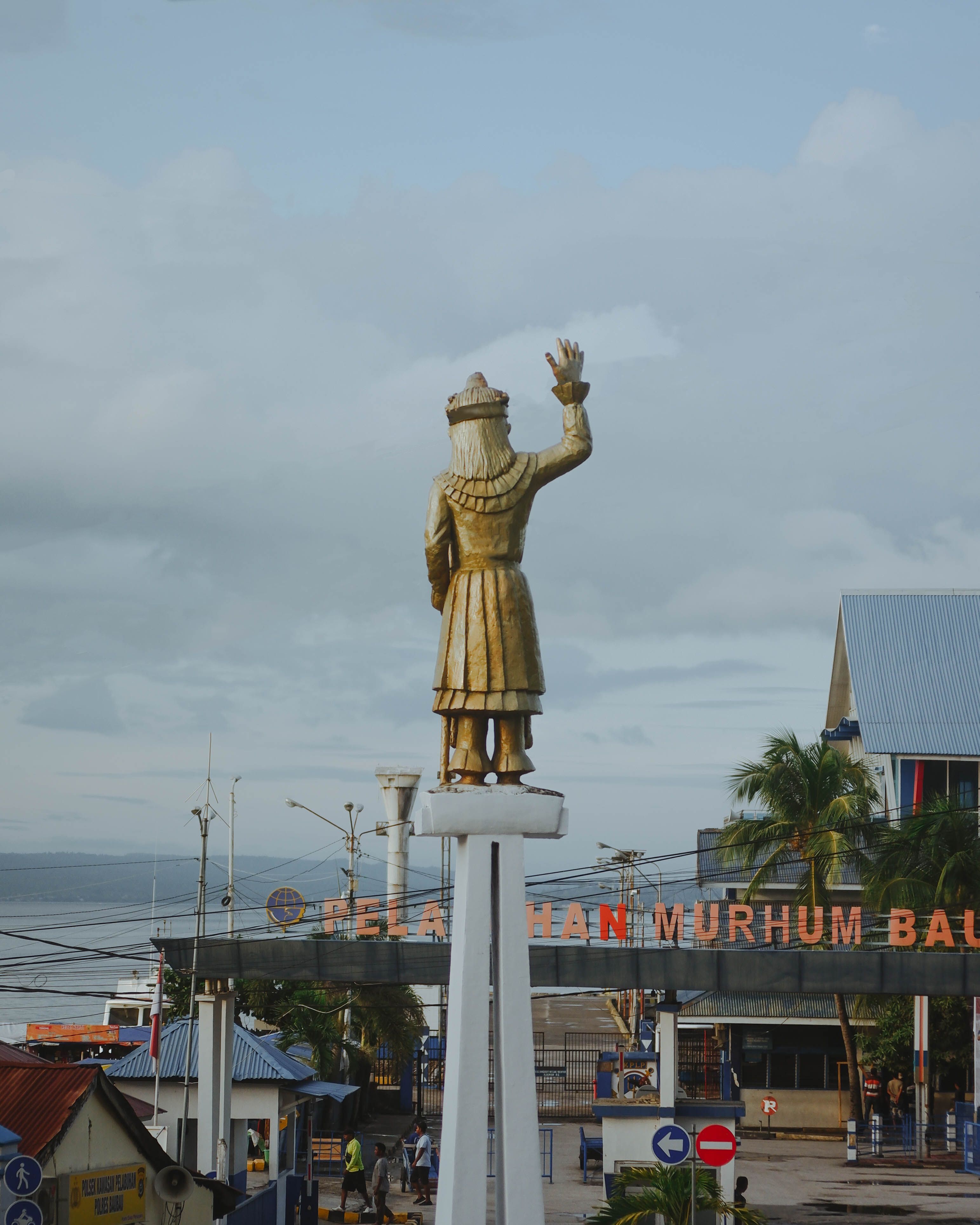 Golden statue at port entrance with ocean view · Free Stock Photo