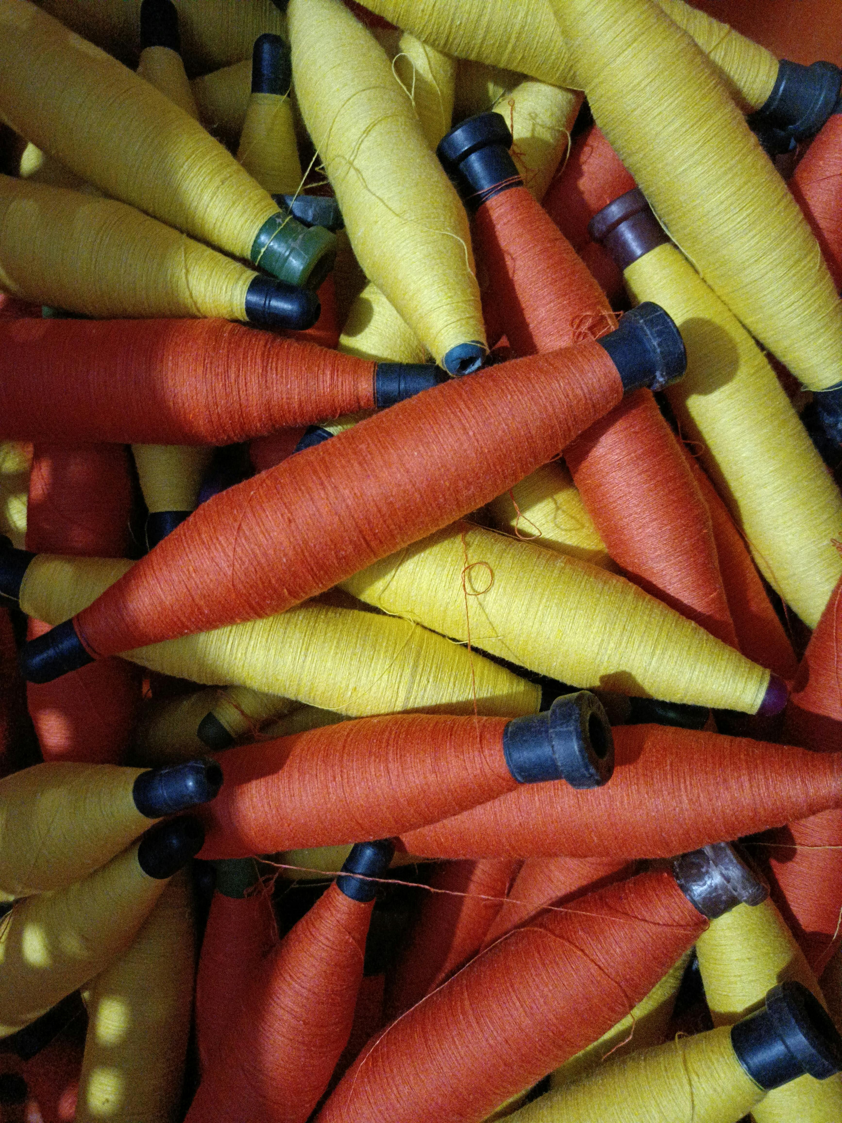 Vibrant Red and Yellow Thread Spools Close-Up · Free Stock Photo