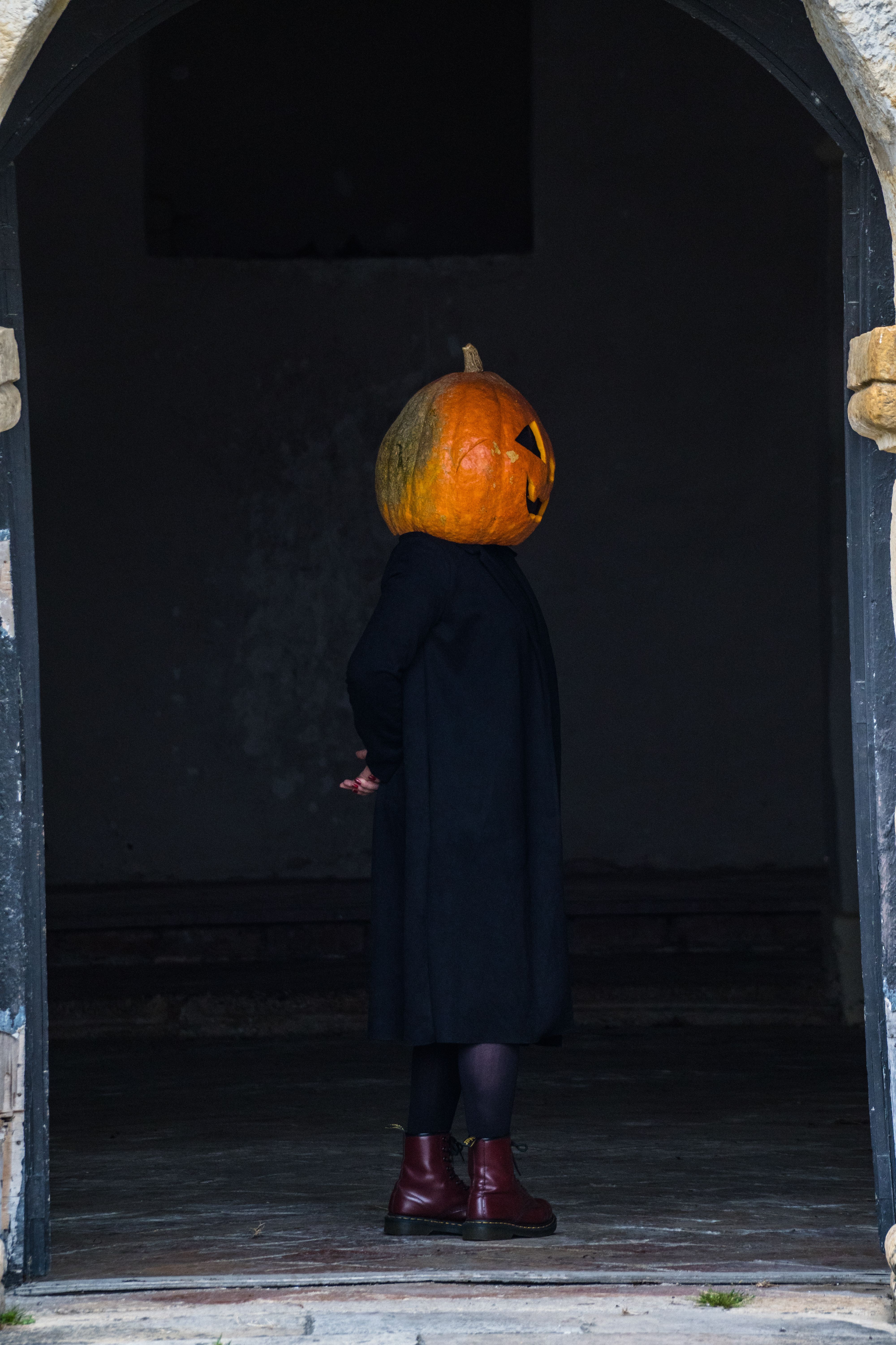 Eerie Pumpkin Head Figure in Doorway · Free Stock Photo